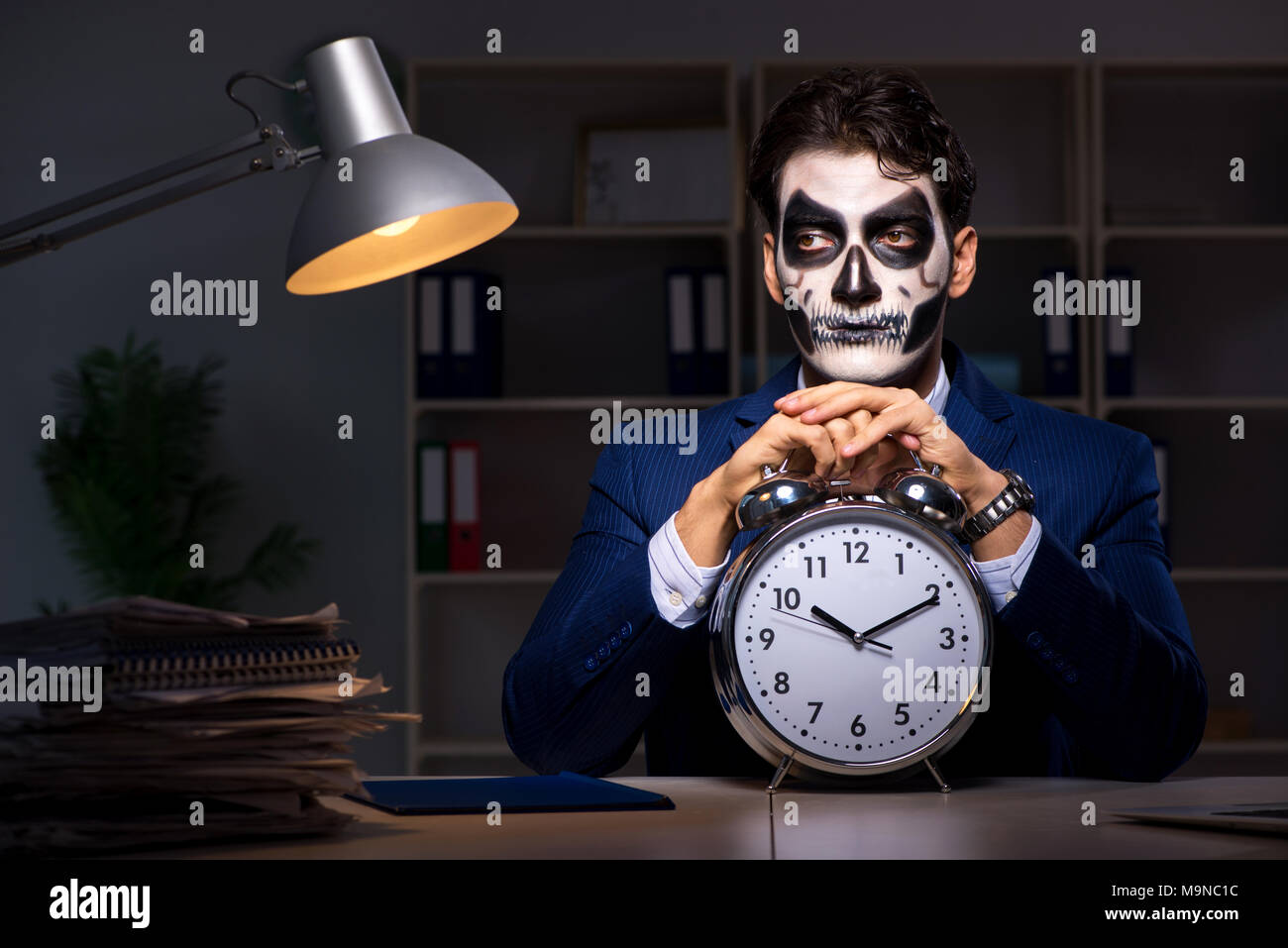 Businessman with scary face mask working late in office Stock Photo - Alamy