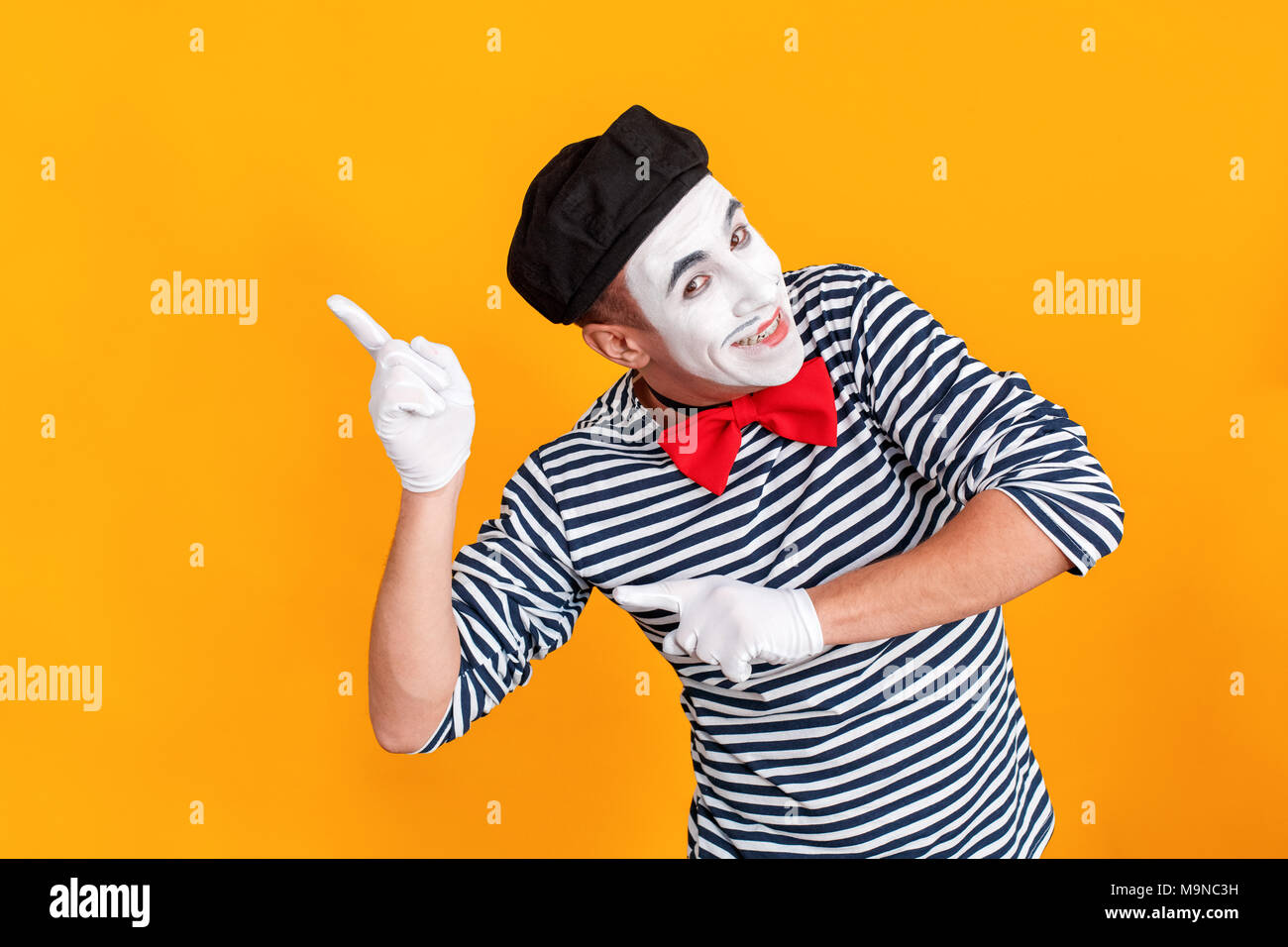 Mime man pointing fingers at copy space and toothy smiling. Emotions ...