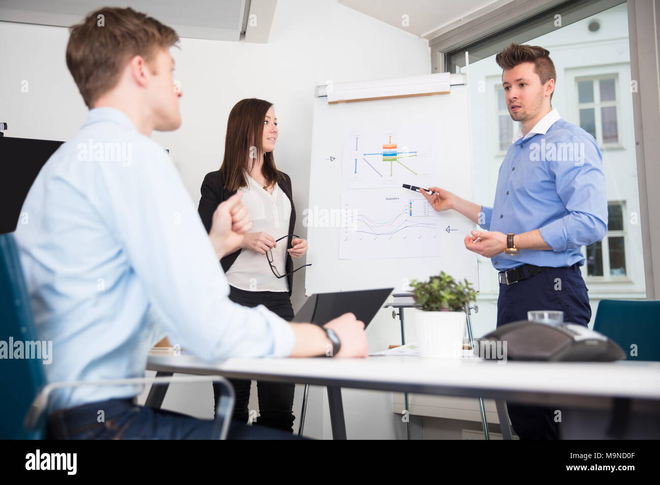 Executive Explaining Presentation To Coworkers In Office Stock Photo ...