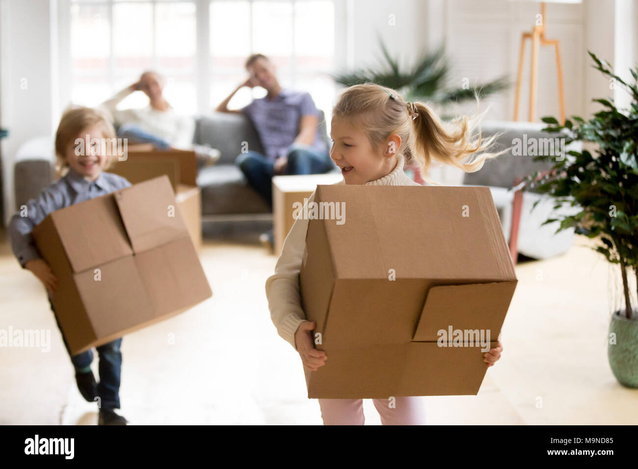 Active children enjoying moving day running carrying boxes, excited ...