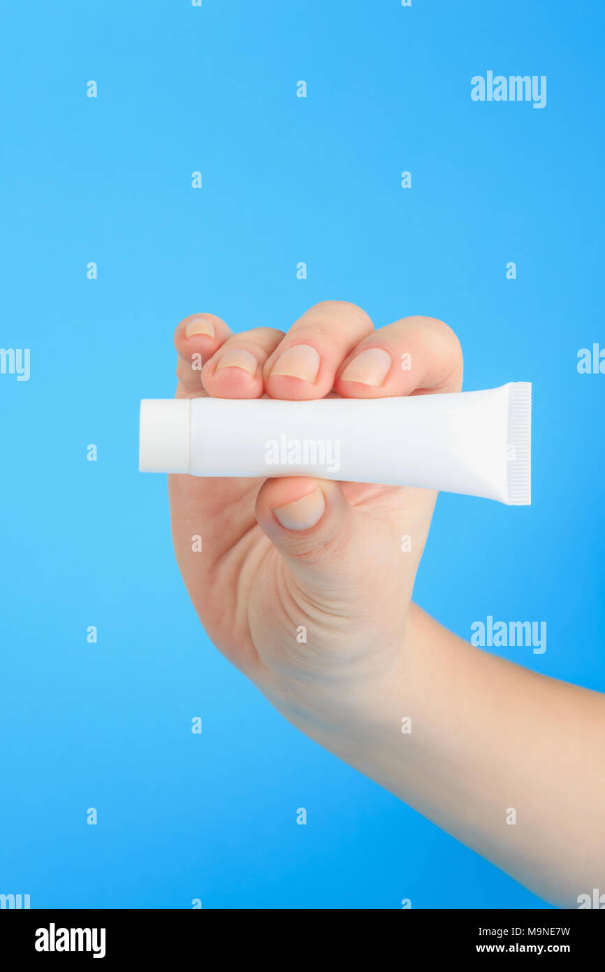 cream advertising, female hand holds the white cream tube with copy ...