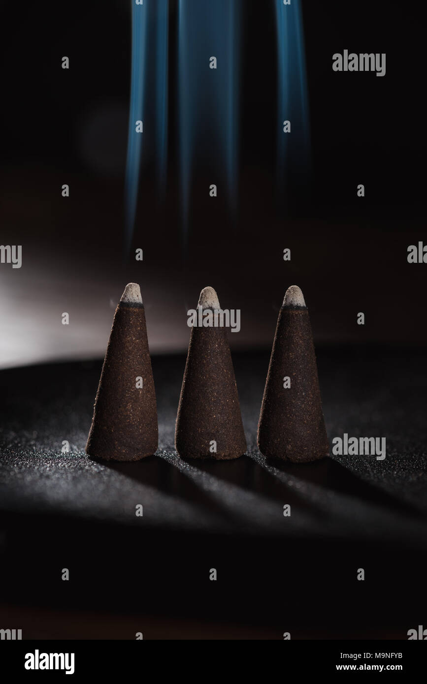 three burning incense sticks with smoke Stock Photo - Alamy