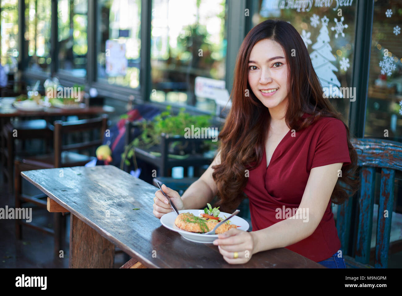 young woman eating food in a restaurant Stock Photo - Alamy