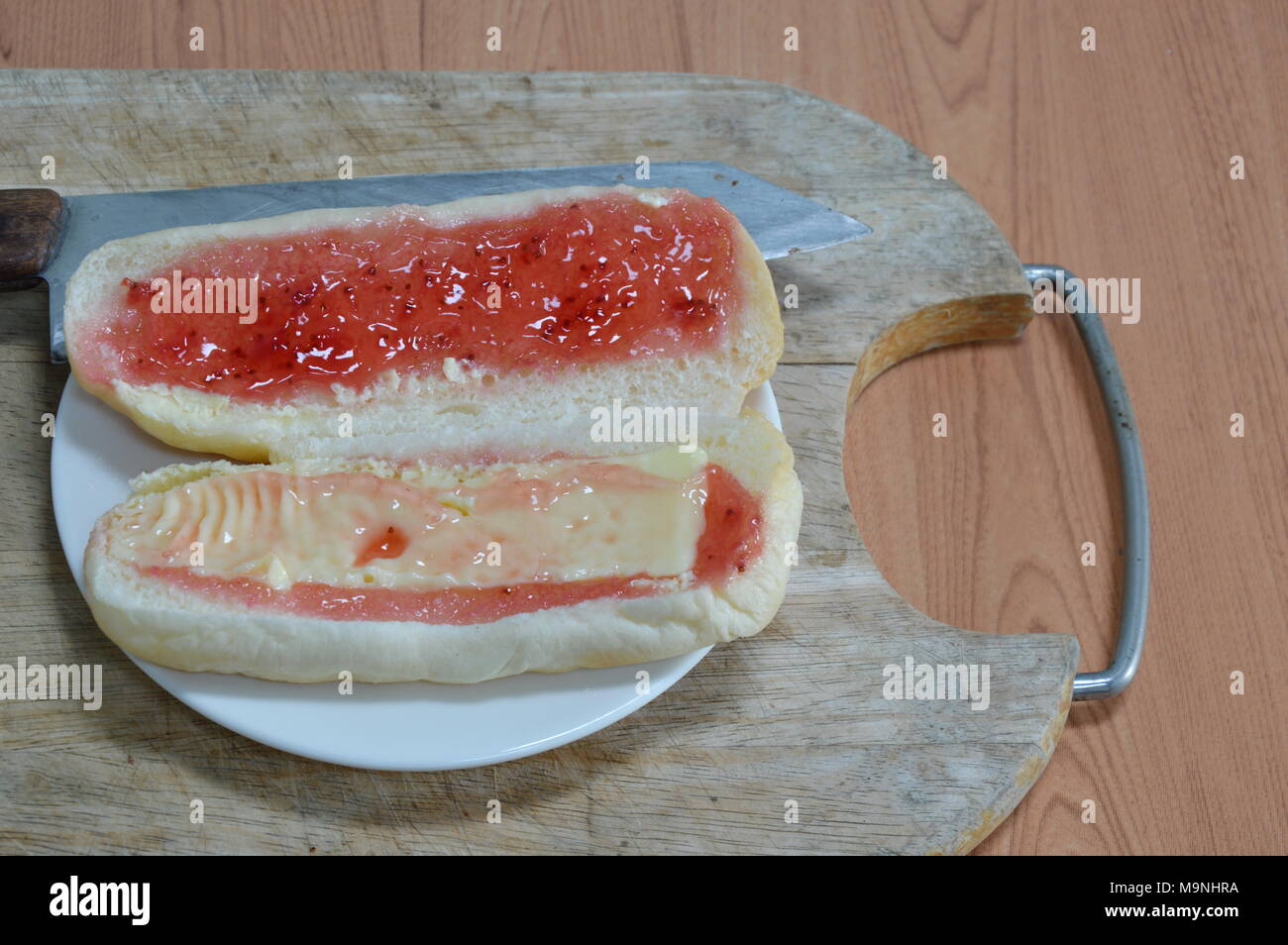 bread filling strawberry jam on wooden chop block Stock Photo - Alamy