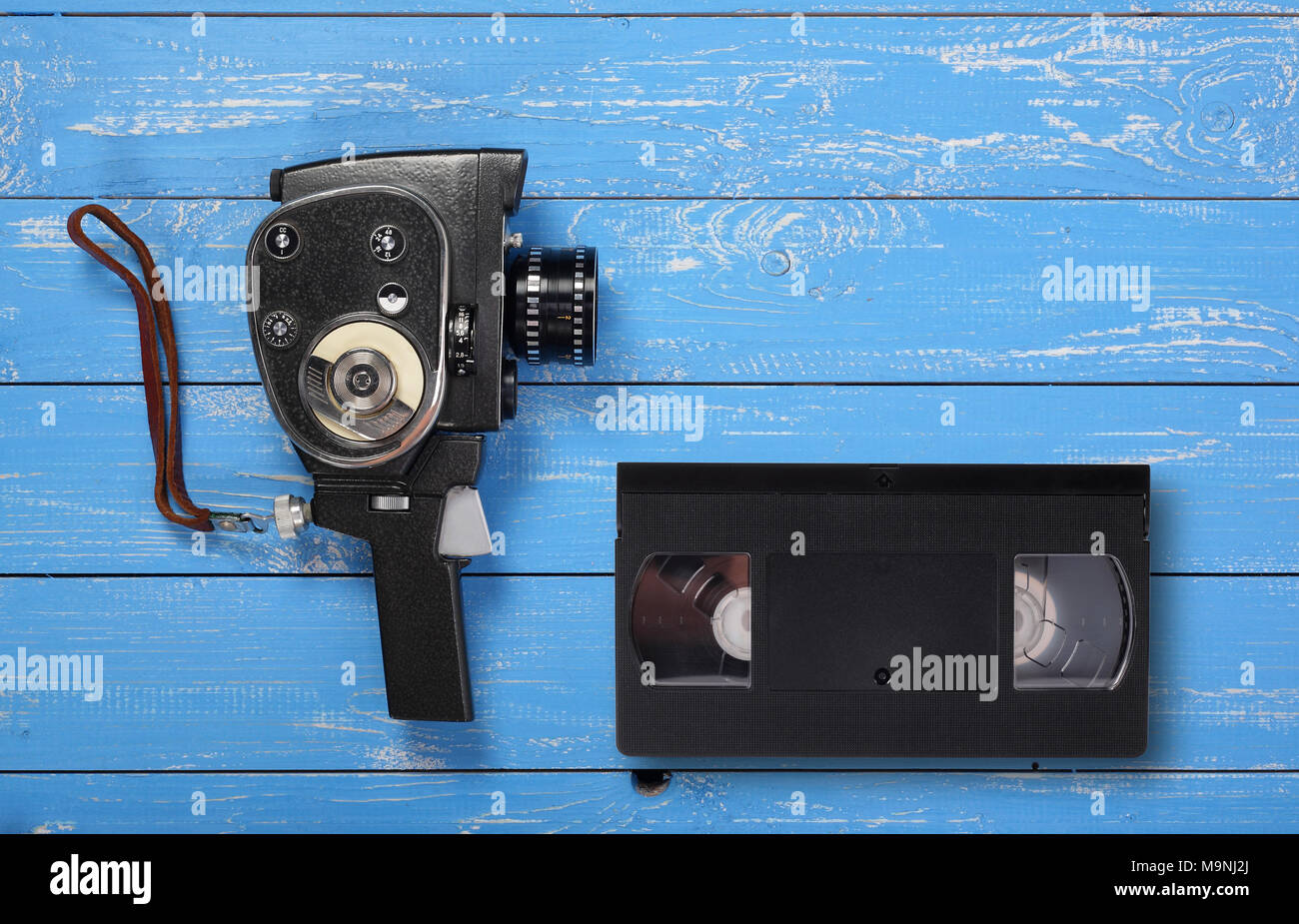 Vintage portable movie film camera Videotape VHS on a blue wooden ...