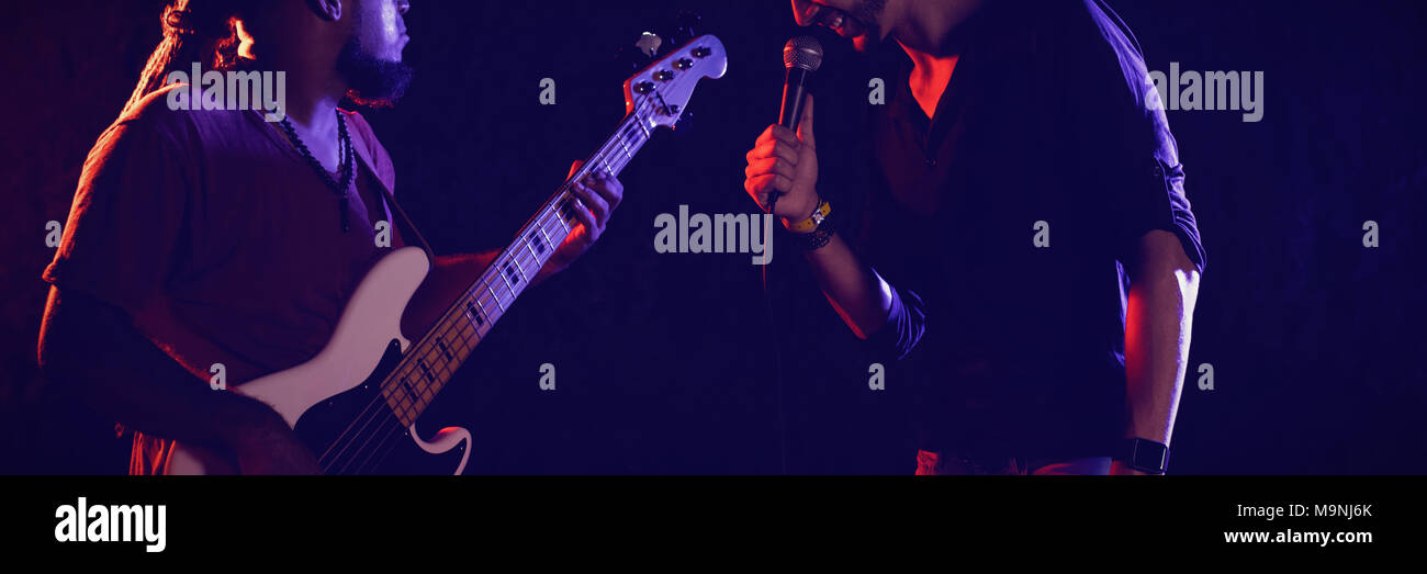 Male singer with guitarist performing at music concert Stock Photo - Alamy