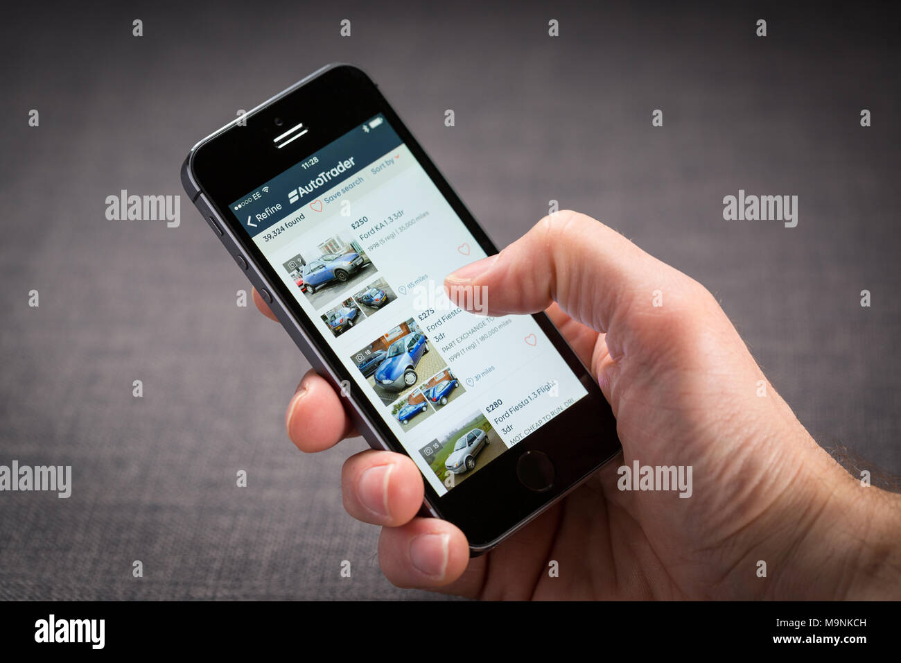 A man using the Autotrader app on an iPhone Stock Photo - Alamy