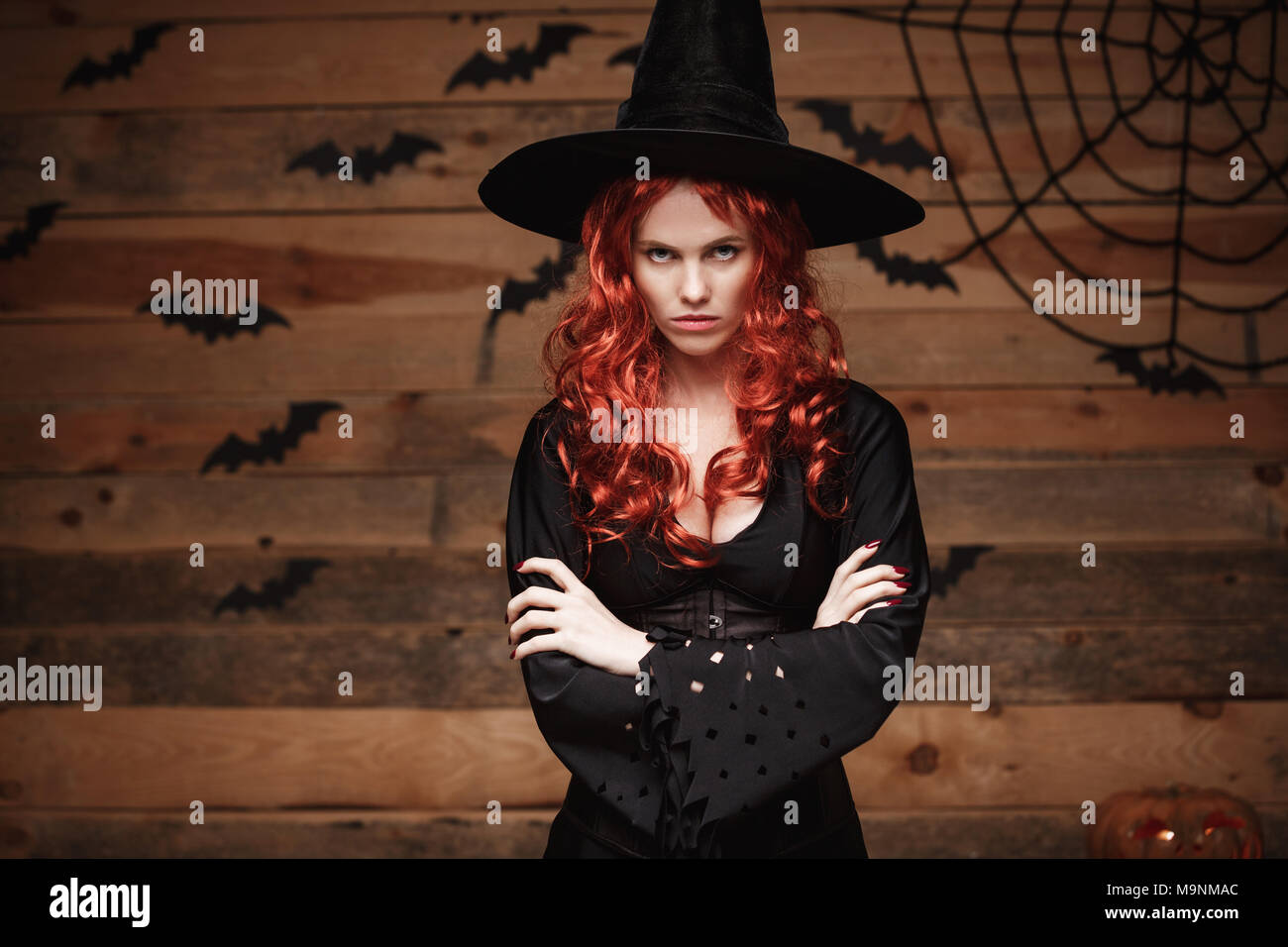 Halloween red hair Witch holding arms posing with angry face over old ...