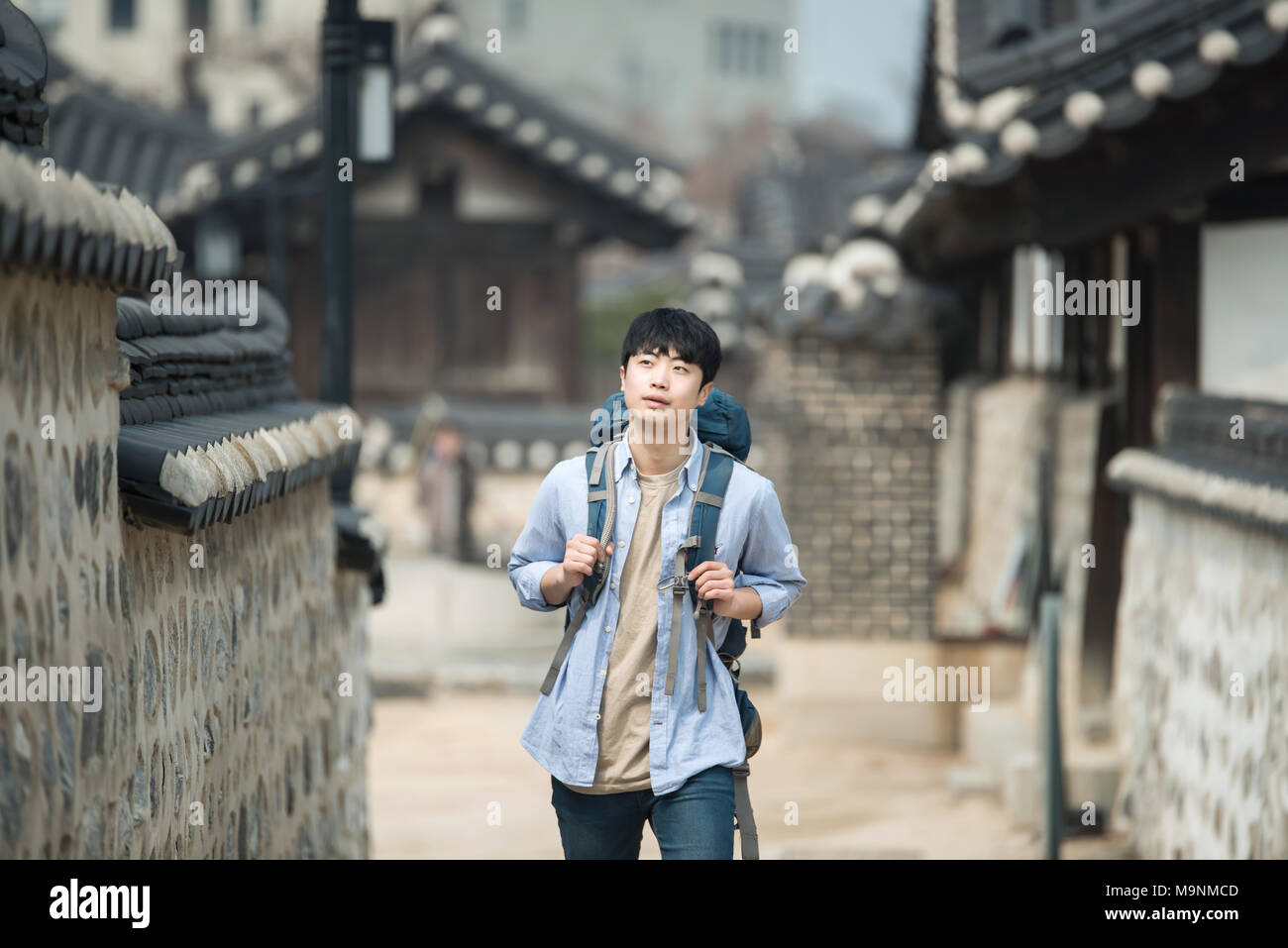 A young man doing a backpacking trip in a Korean traditional house ...