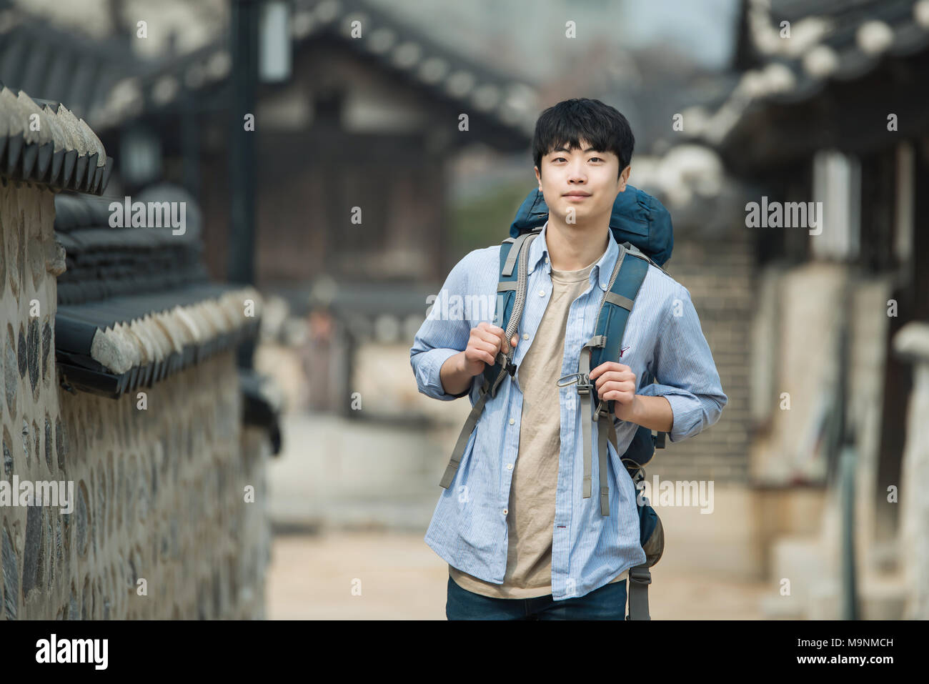 A young man doing a backpacking trip in a Korean traditional house ...