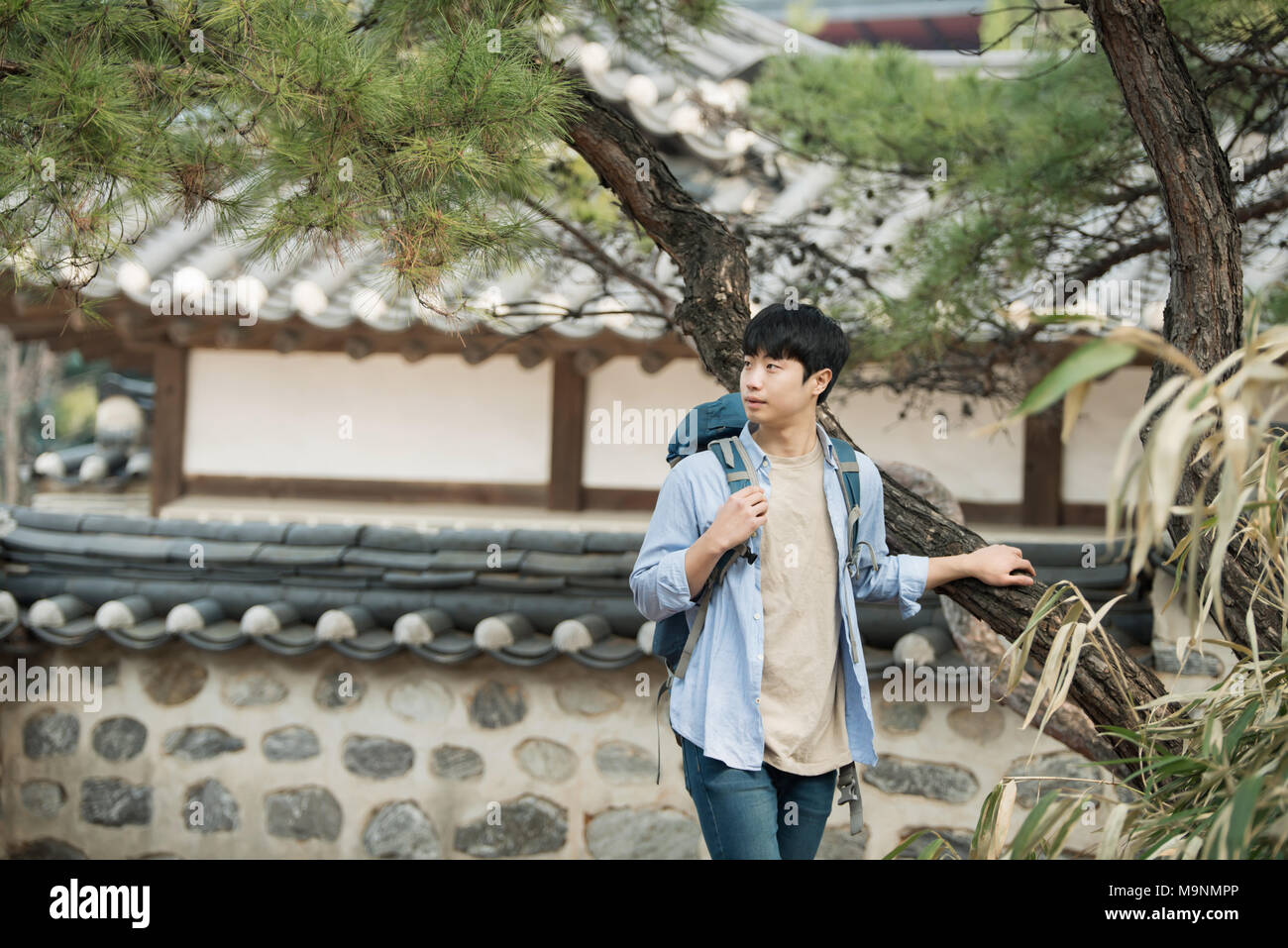 A young man doing a backpacking trip in a Korean traditional house ...