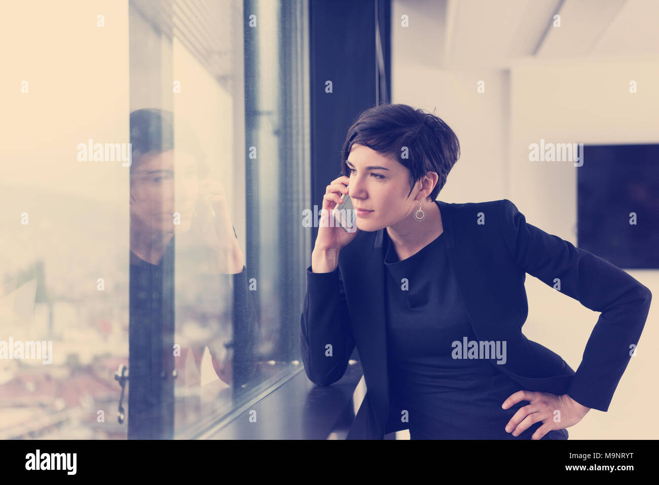 female manager using cell telephone in office interior Stock Photo - Alamy
