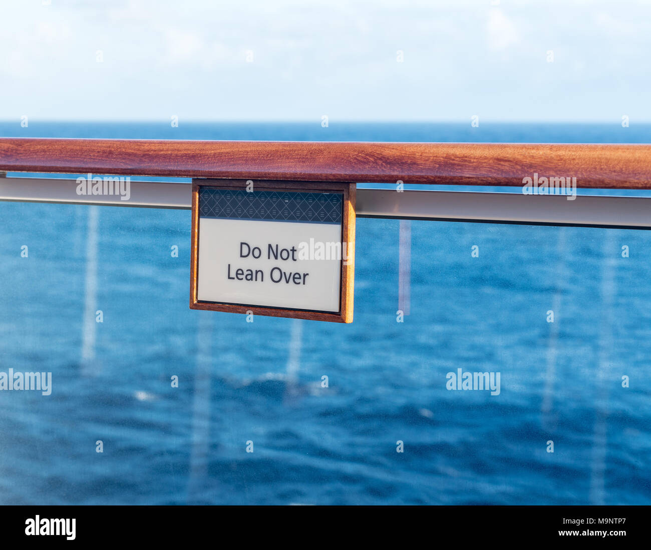 Do Not Lean Over warning sign on railing of cruise ship Stock Photo - Alamy