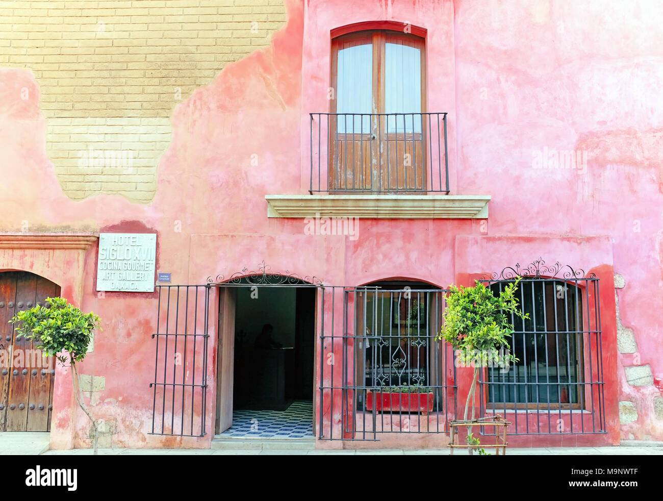 A pink and yellow building with bars on the windows in Oaxaca, Mexico ...