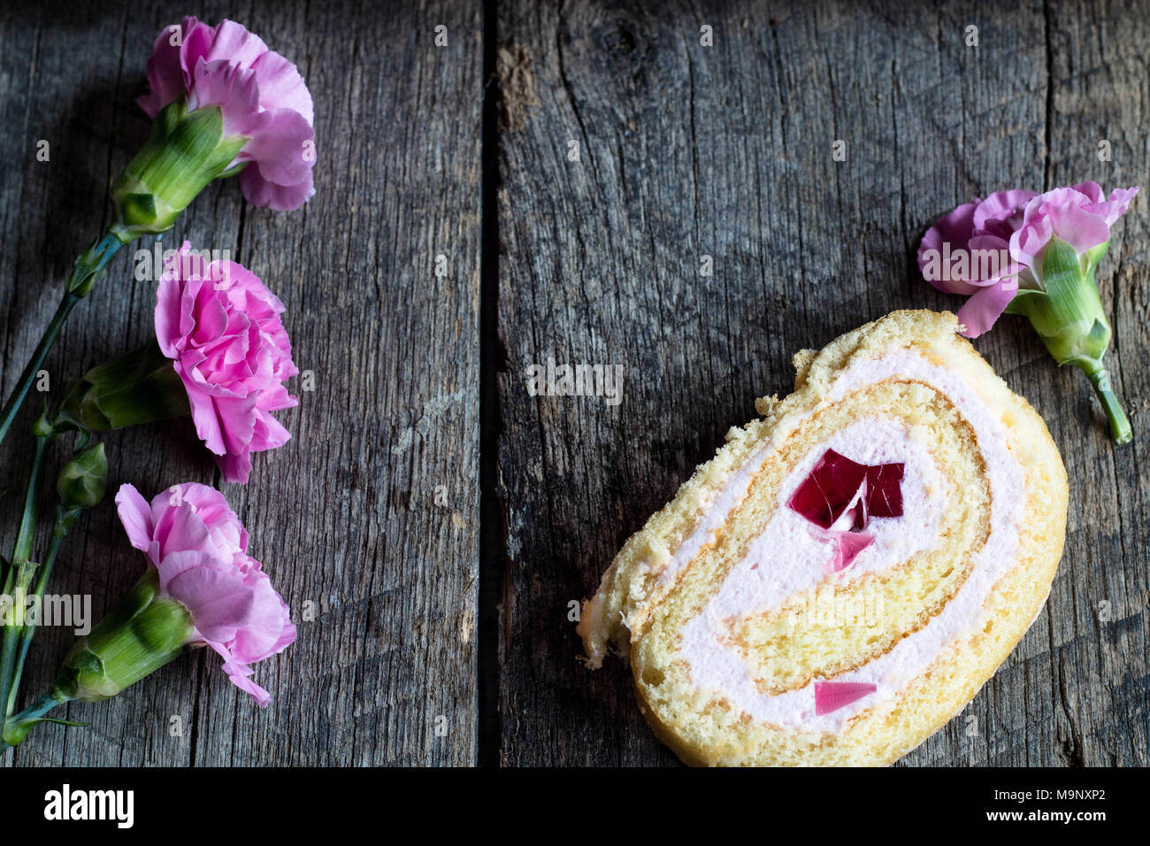 dough biscuit roll, wooden bobbins and pink carnation flowers on wooden ...