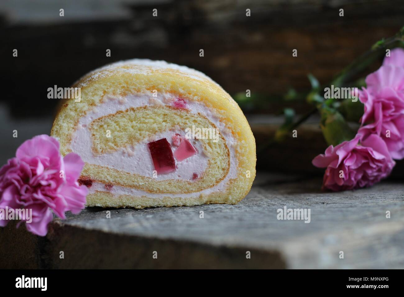 dough biscuit roll, wooden bobbins and pink carnation flowers on wooden ...