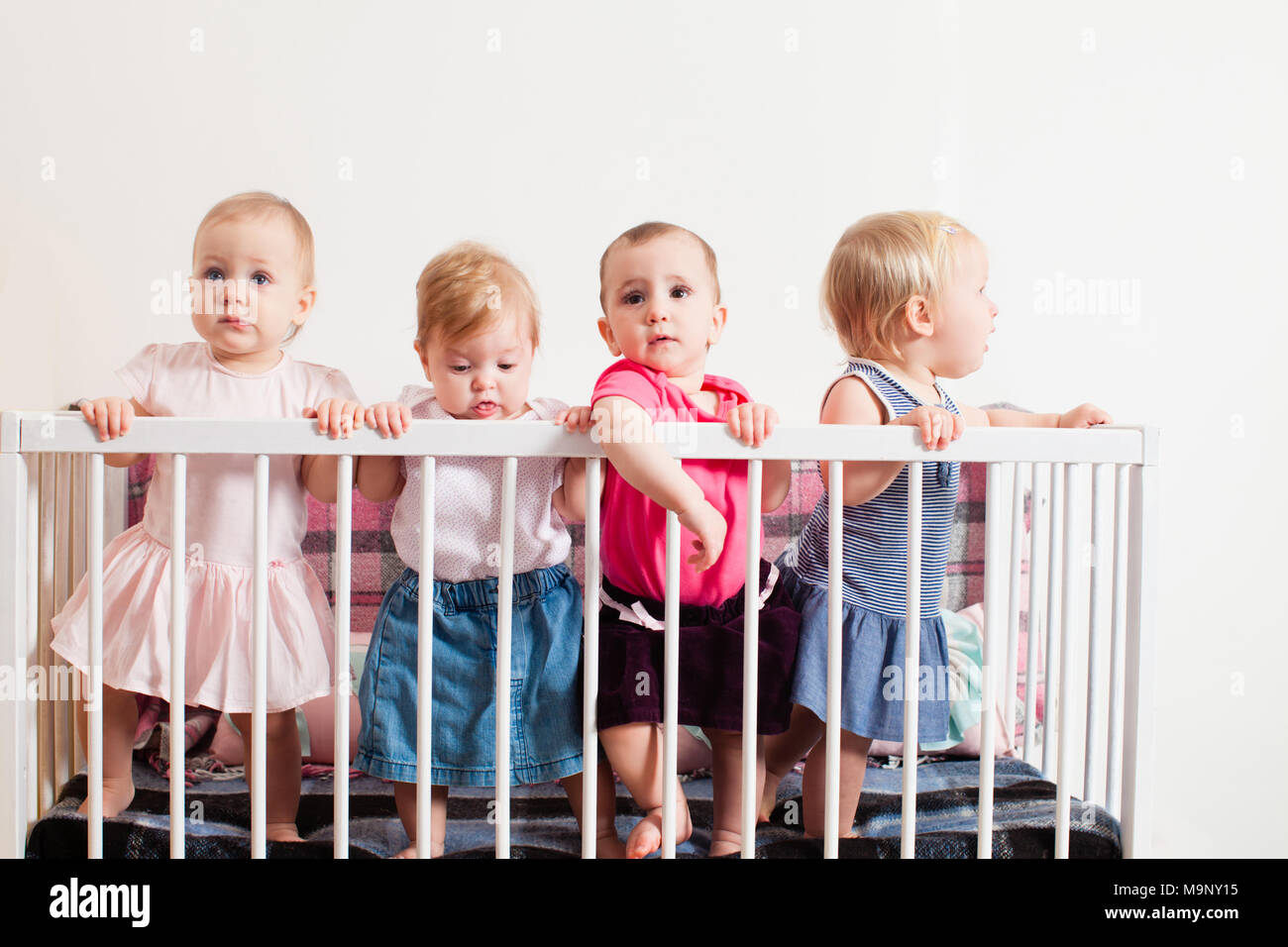 Three baby girls in the crib Stock Photo - Alamy