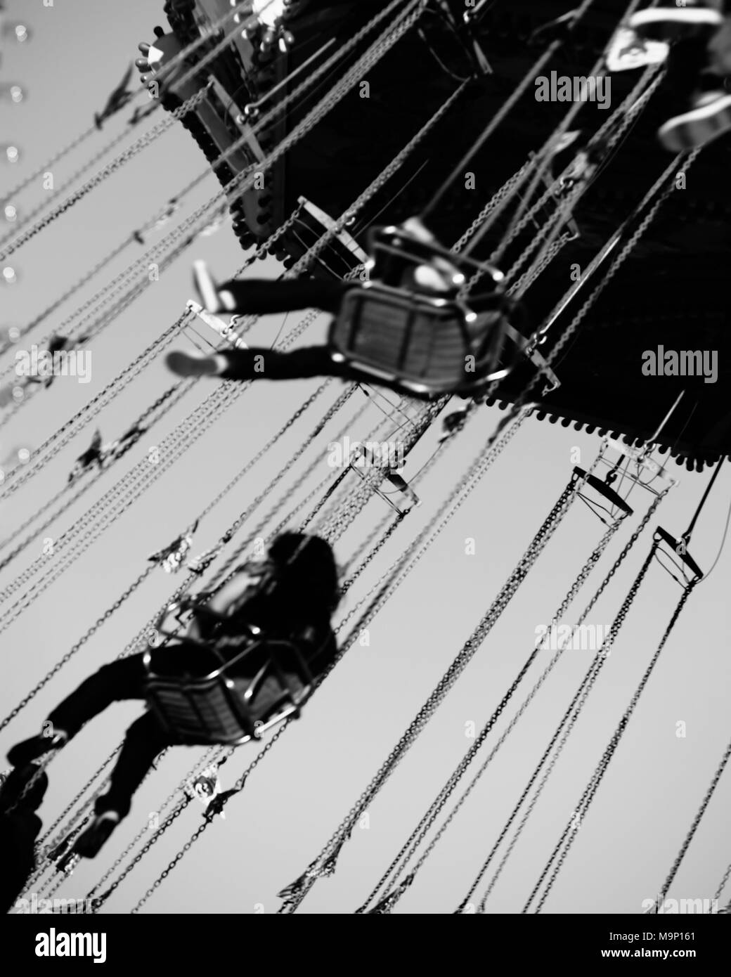 Rear view of a seated person hanging on a carnival ride Stock Photo - Alamy