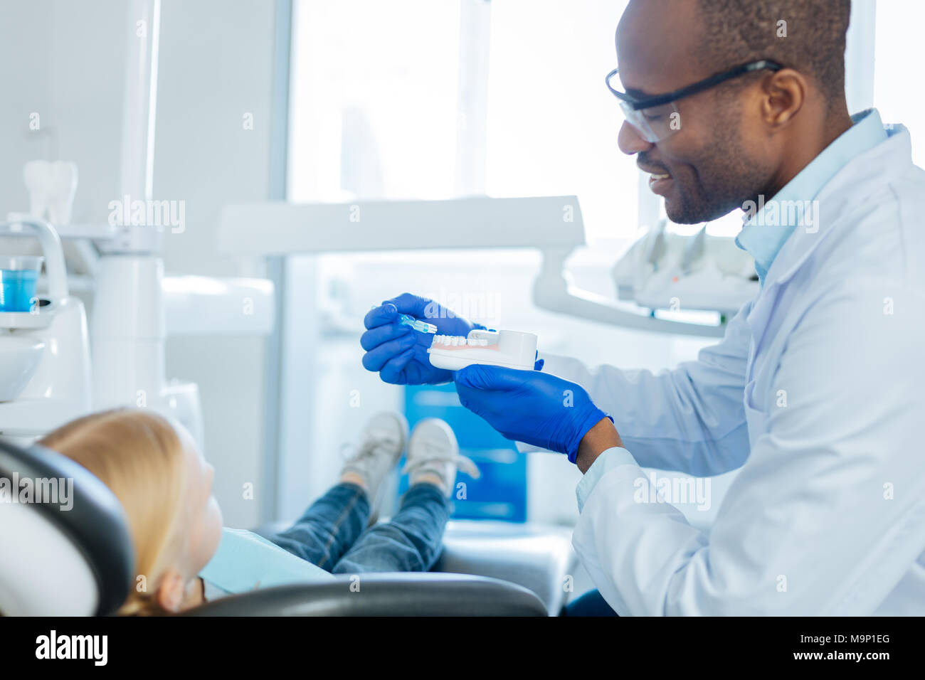 Little girl listening to dentist talking about teeth care Stock Photo ...