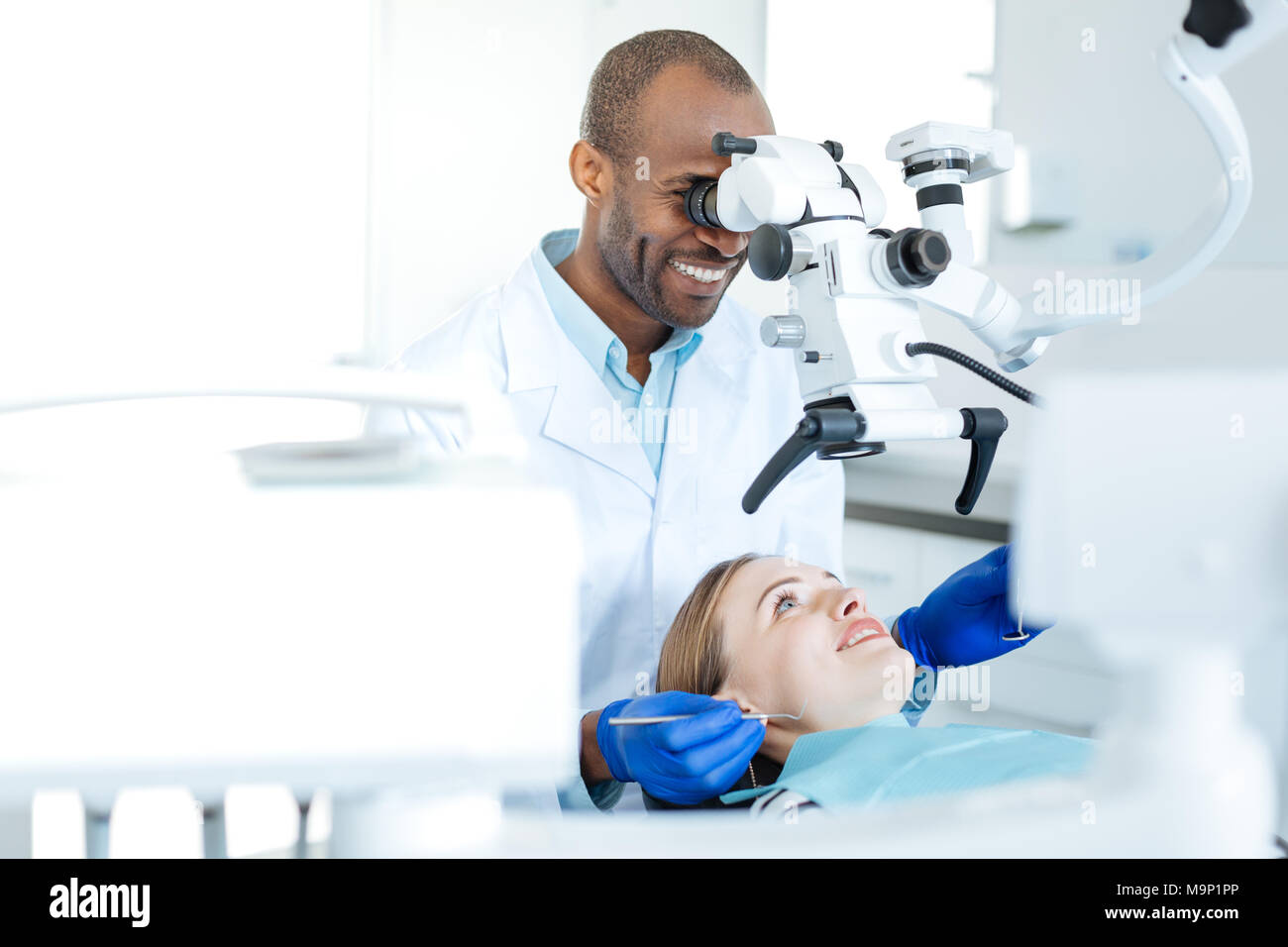 Skilled dentist magnifying his patients teeth with microscope Stock ...