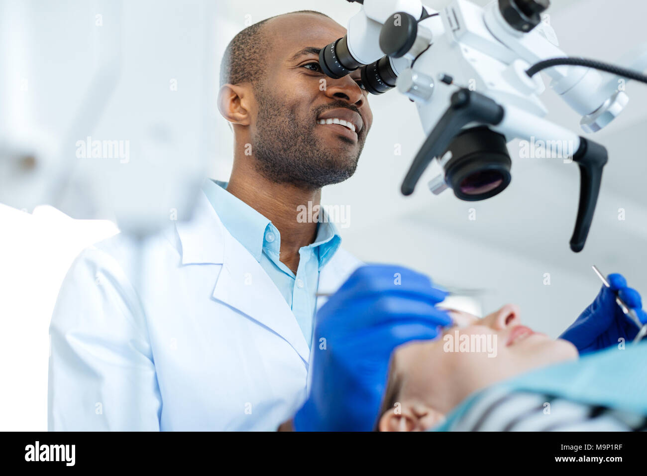 Professional dentist conducting checkup of cavity with microscope Stock ...