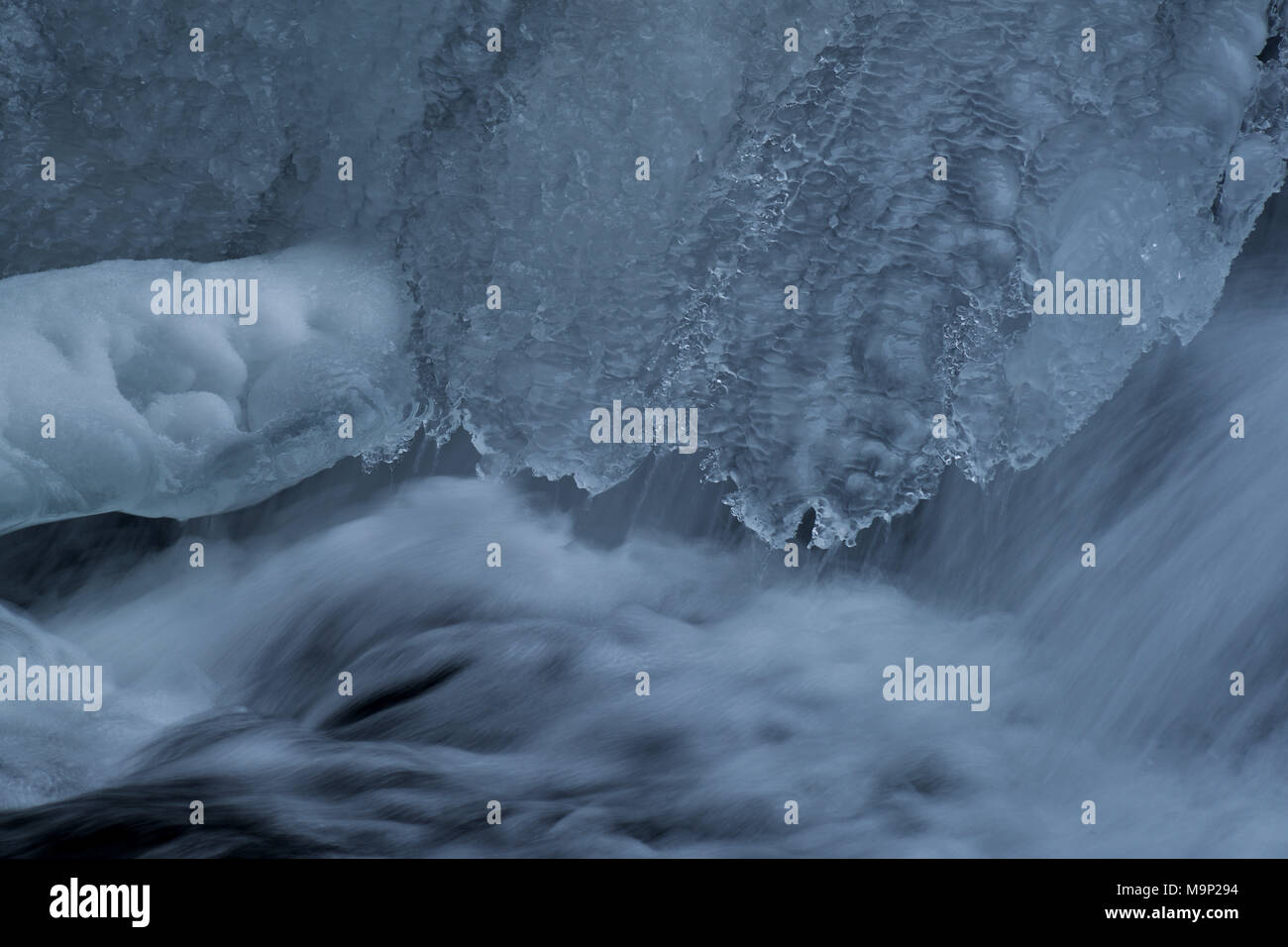 Rapidly flowing cold water through the ice Stock Photo - Alamy