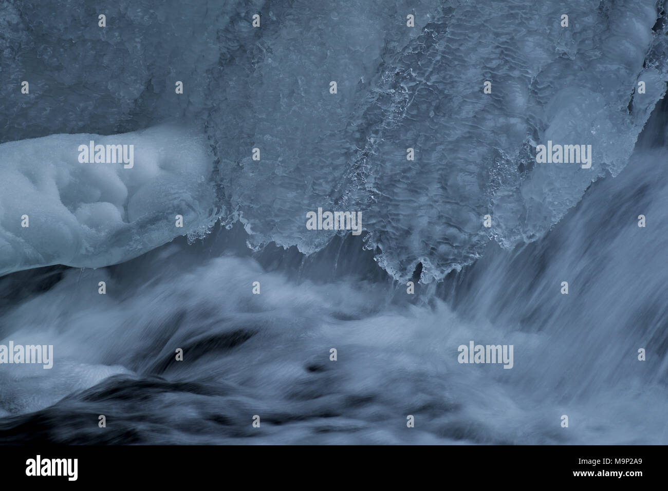 Rapidly flowing cold water through the ice Stock Photo - Alamy