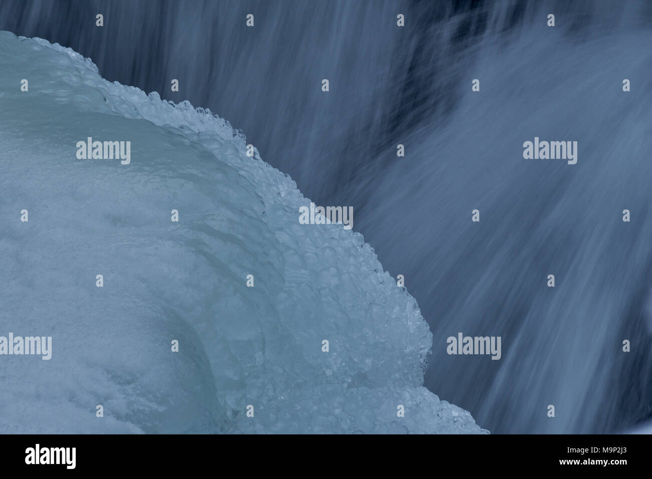 Rapidly flowing cold water through the ice Stock Photo - Alamy