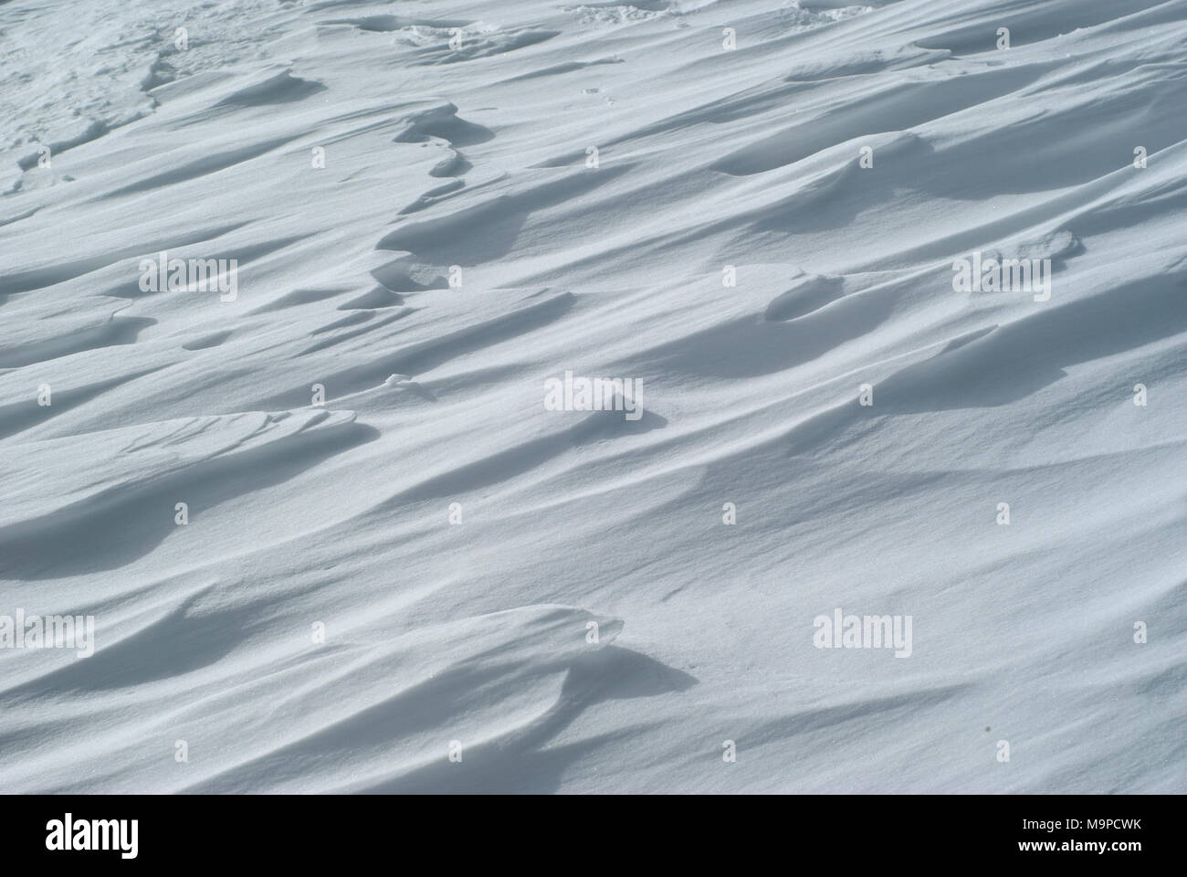 background - surface of firn field with hummocks on the mountain slope ...