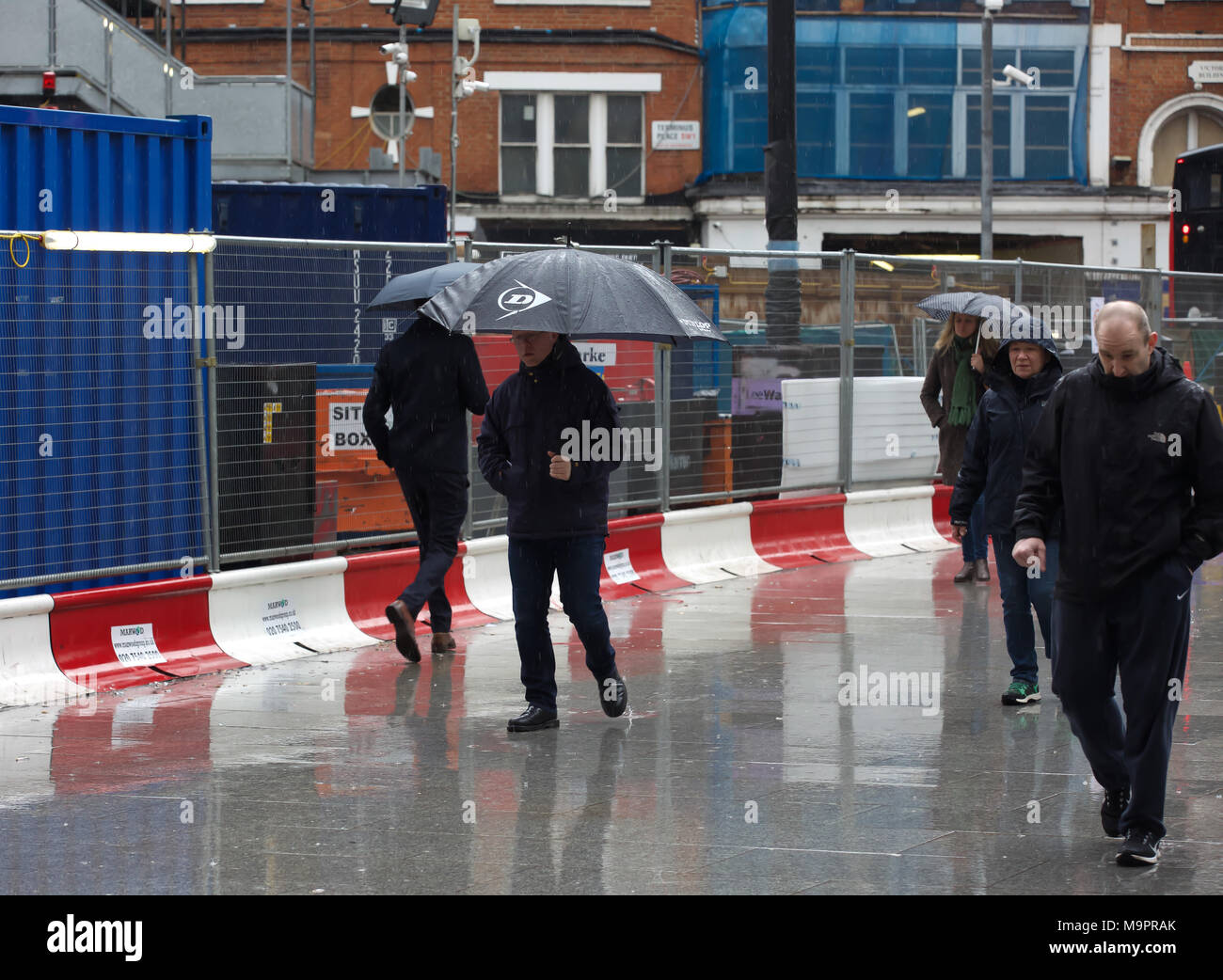 London,UK,28th March 2018,People use umbrellas for protection against ...