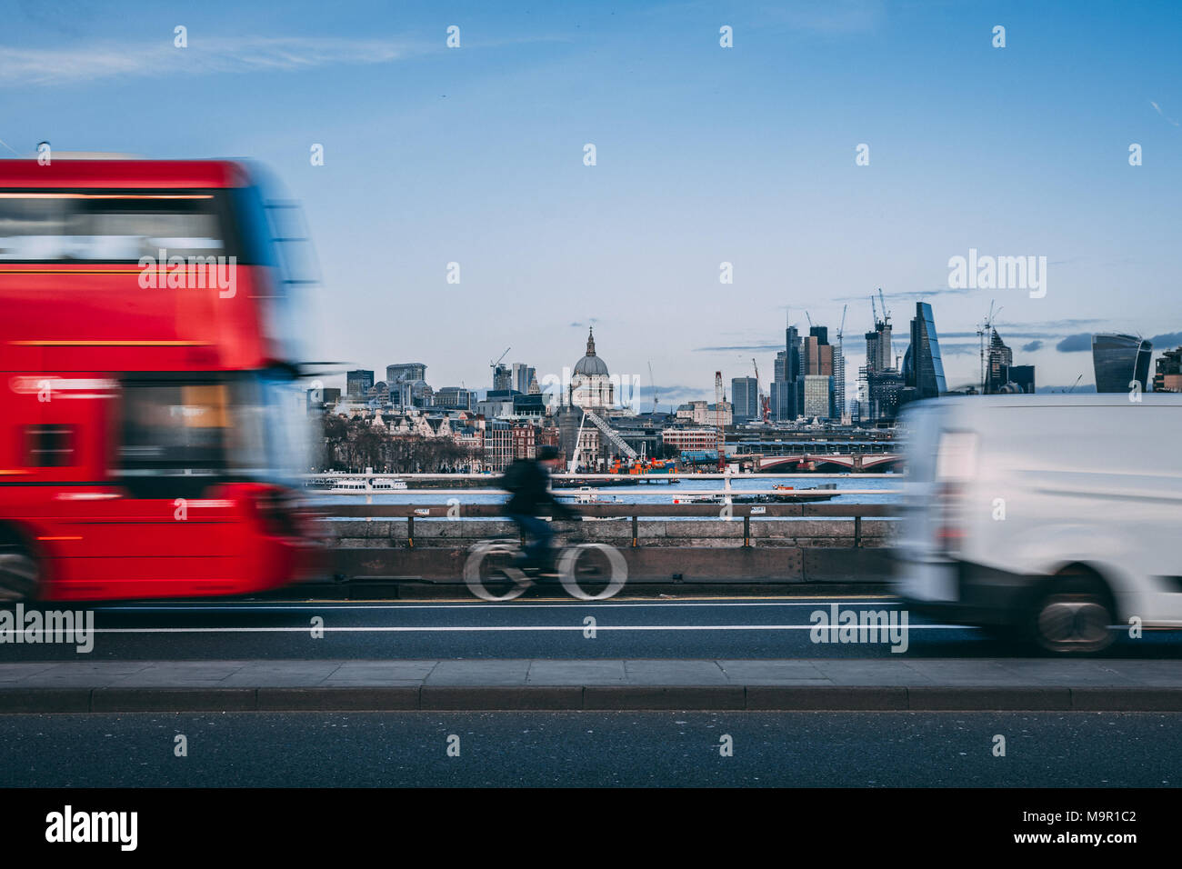 London skyline background with moving traffic of bus, van and bicycle ...