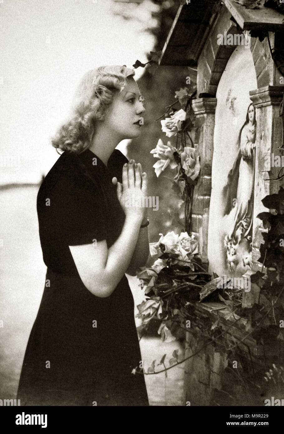 Woman praying in front of Virgin Mary picture, 1920s, Germany Stock ...