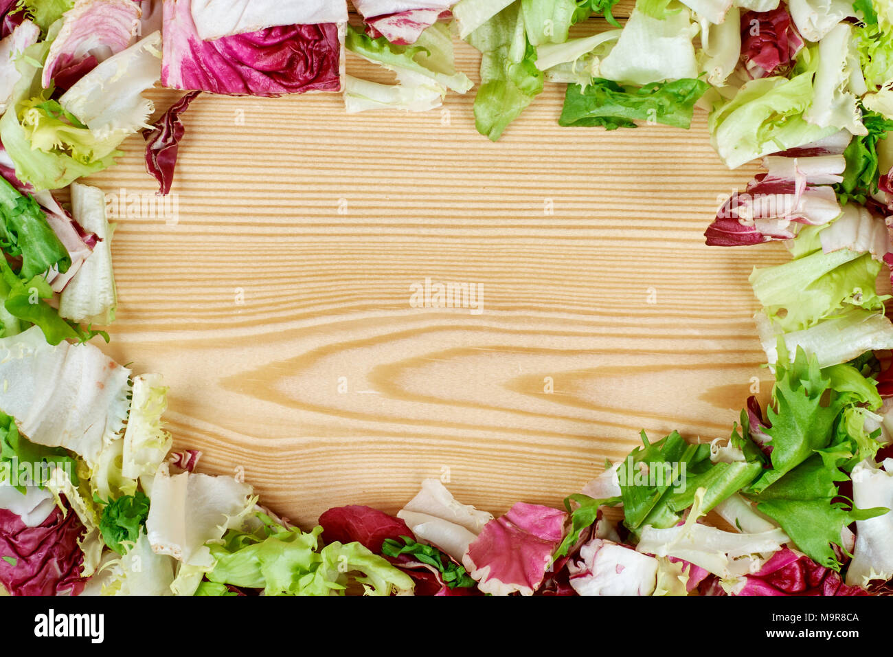 Frame of fresh green salad on wooden background. Healthy natural food ...