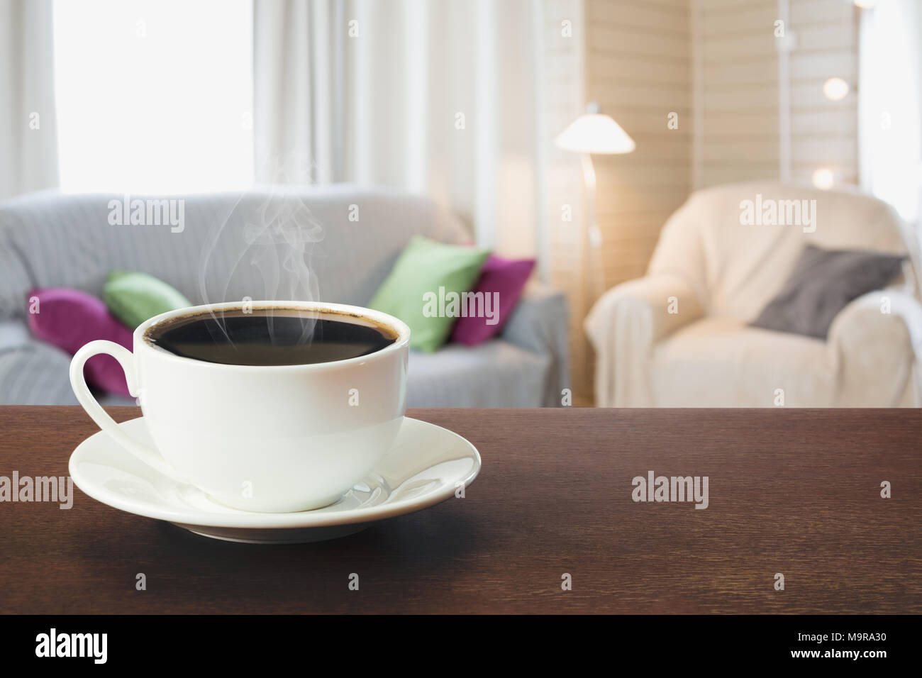 Hot cup of black coffee on tabletop in modern living room in rustic ...