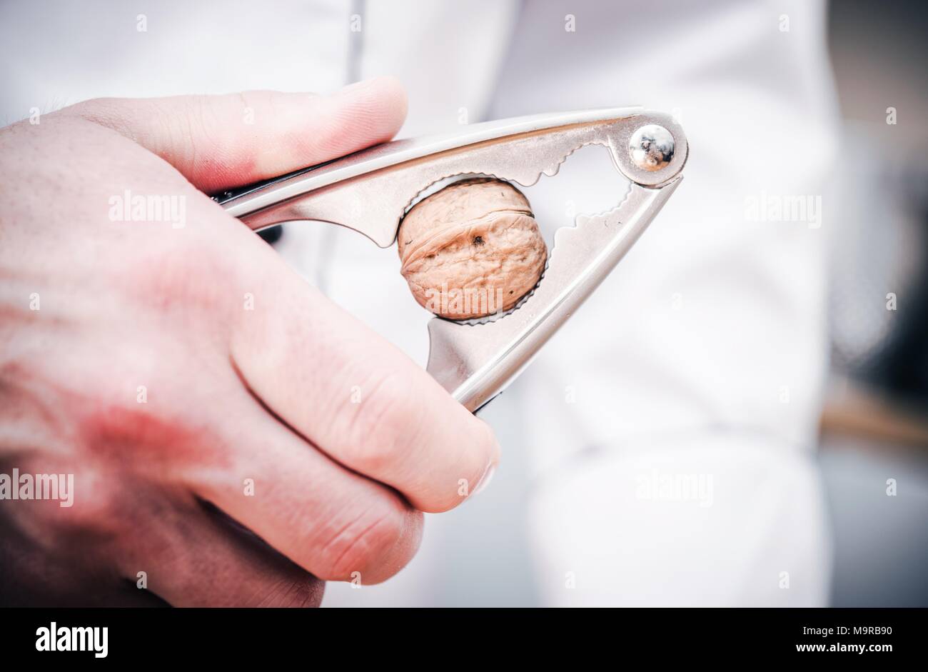 Walnut Inside Nut Cracker. Cracking the Nut in the Kitchen by Caucasian ...