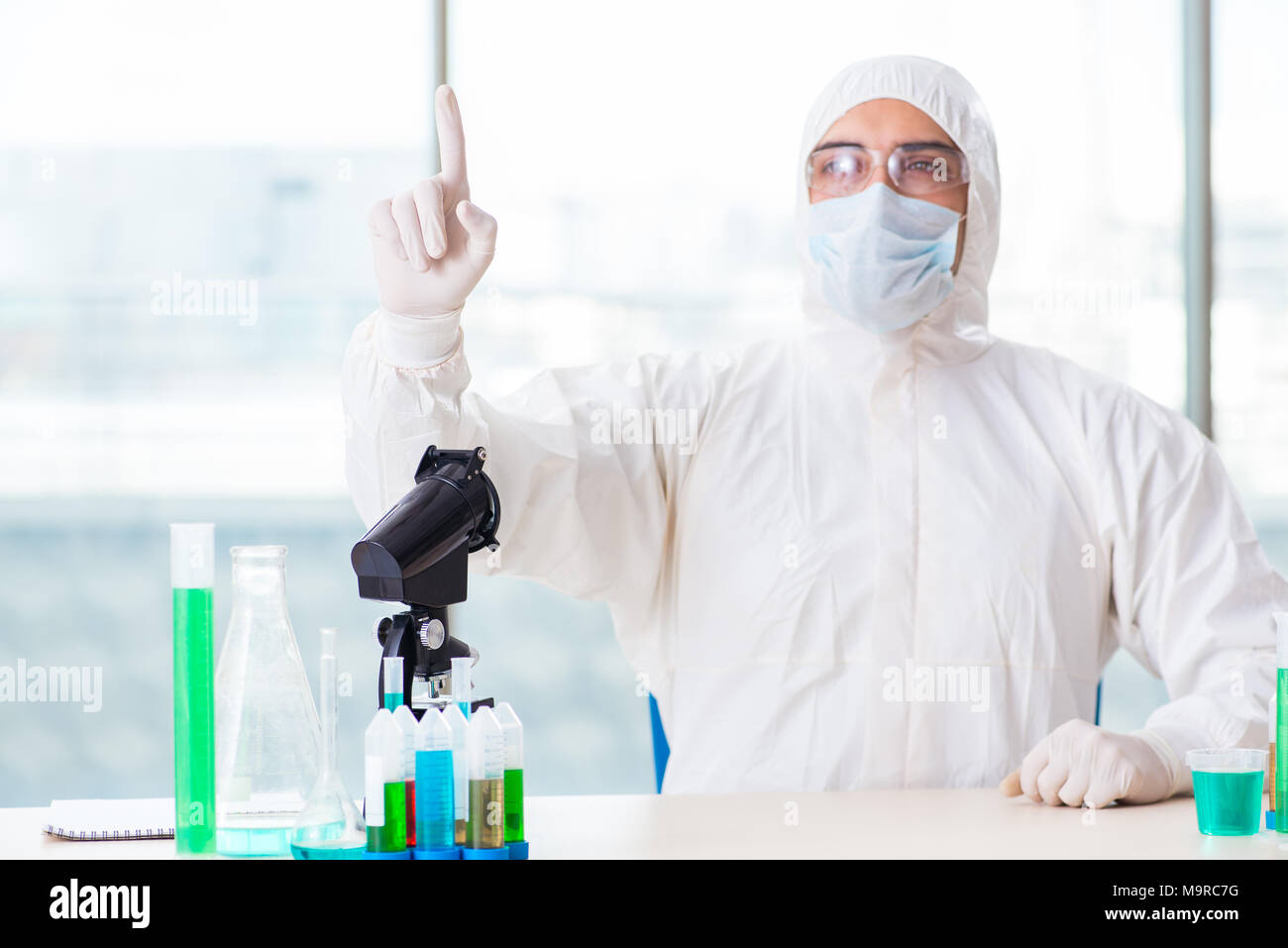 Young chemist pressing virtual buttons in lab Stock Photo - Alamy