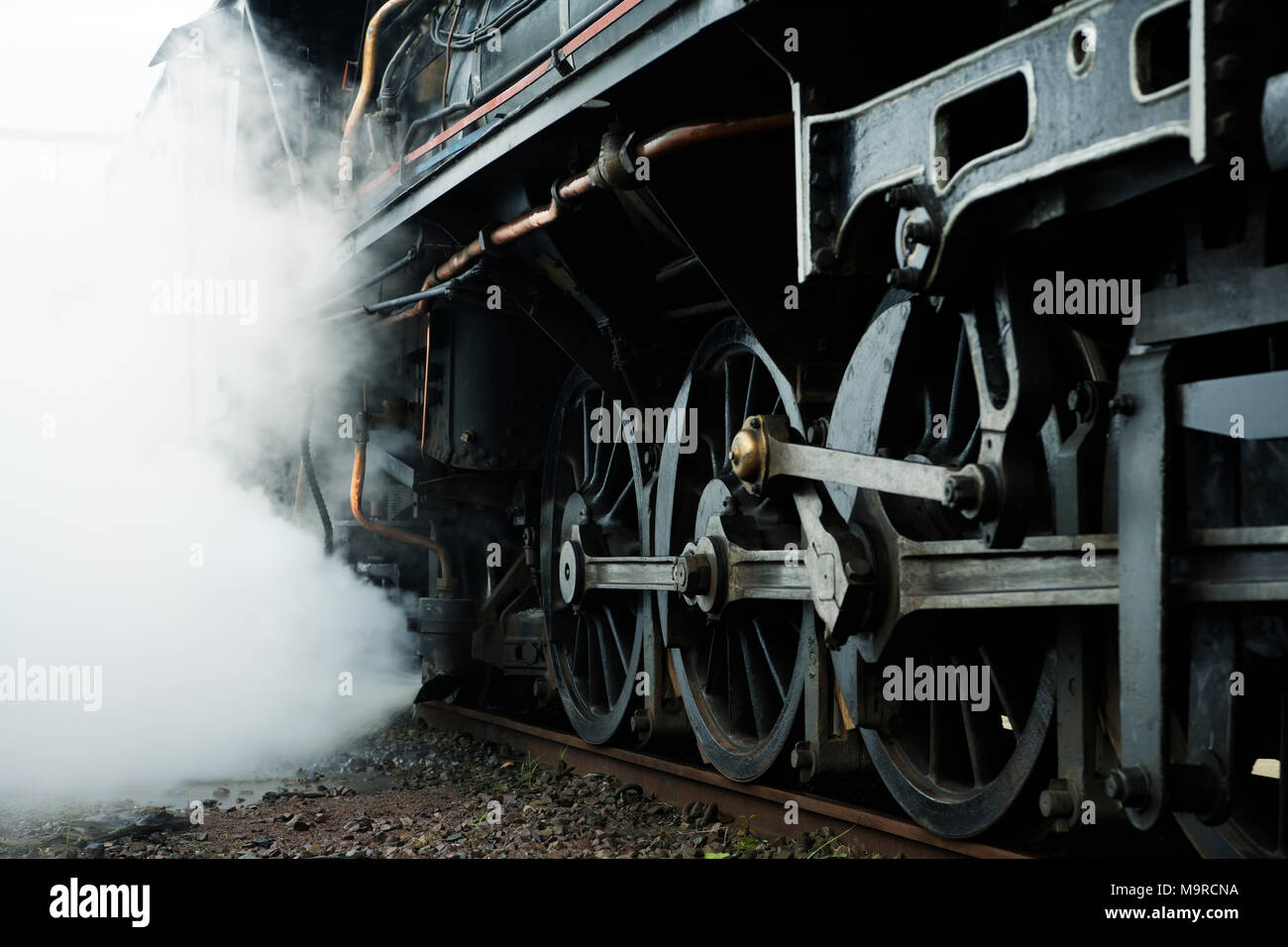Close-up, detail, discharge valve releasing steam, drive wheels of ...