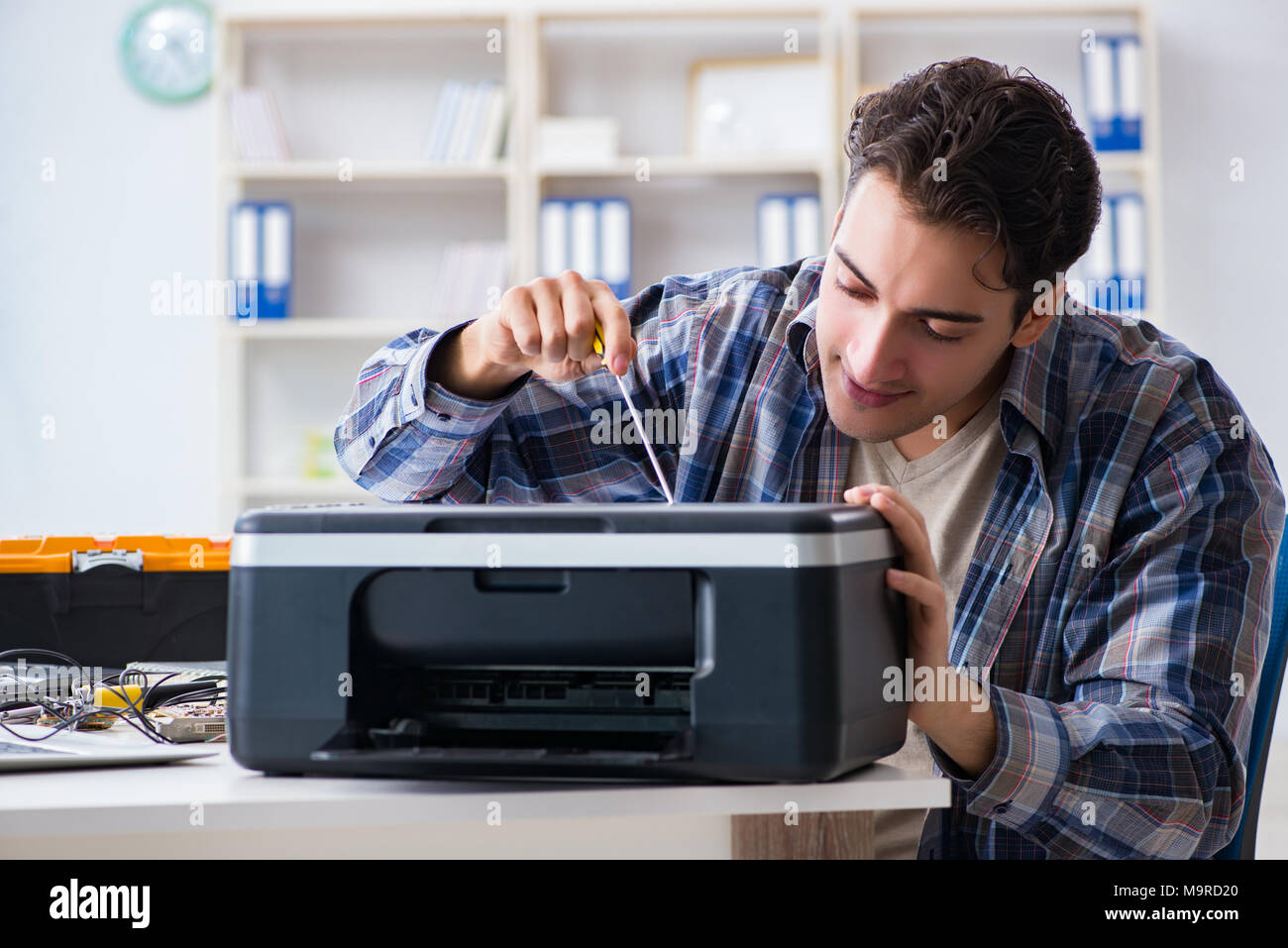 Hardware repairman repairing broken printer fax machine Stock Photo - Alamy