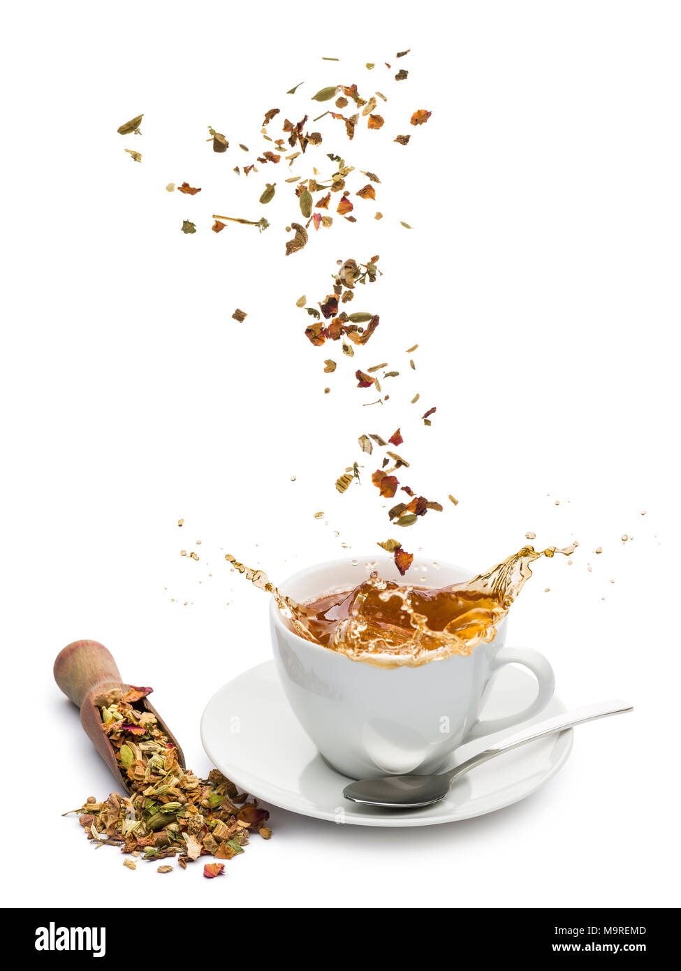 cup of tea with tea mixture falling and splashing on white background ...