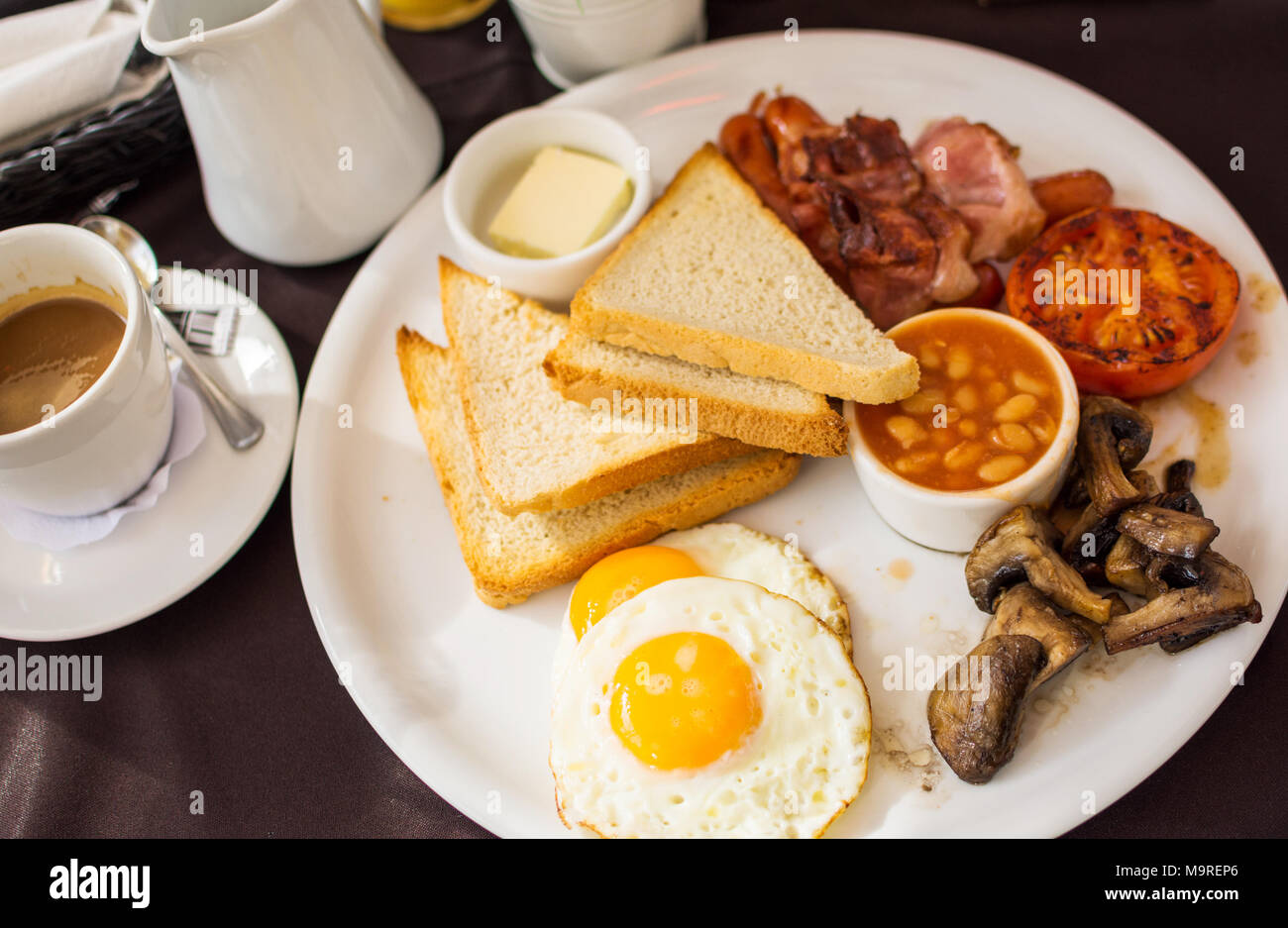 Traditional Full English Breakfast with sunny-side-up fried eggs, bacon ...