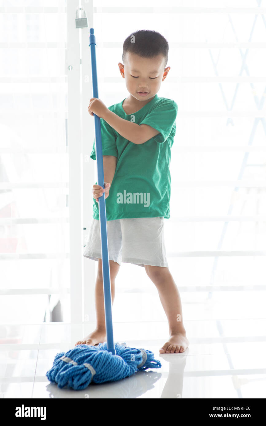 Asian boy mopping floor. Young child doing house chores at home Stock ...