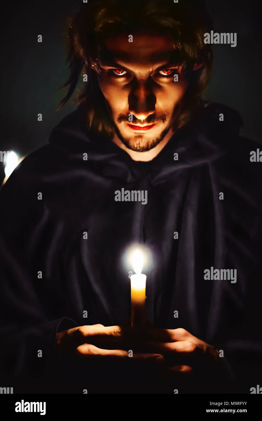 Warlock with a candle in the dark scary look Stock Photo - Alamy