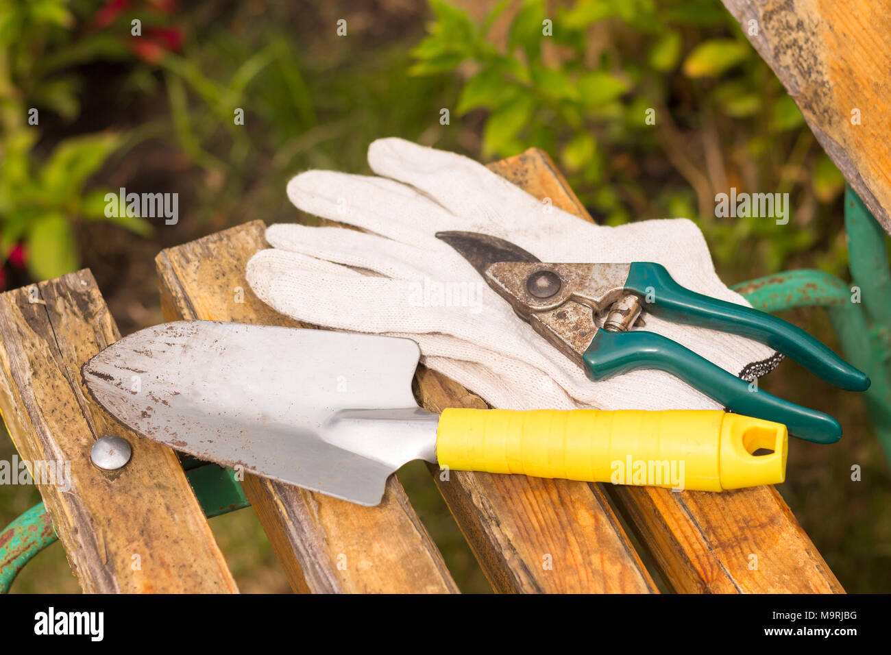 worked dirty garden tools composition laying on a bench Stock Photo - Alamy