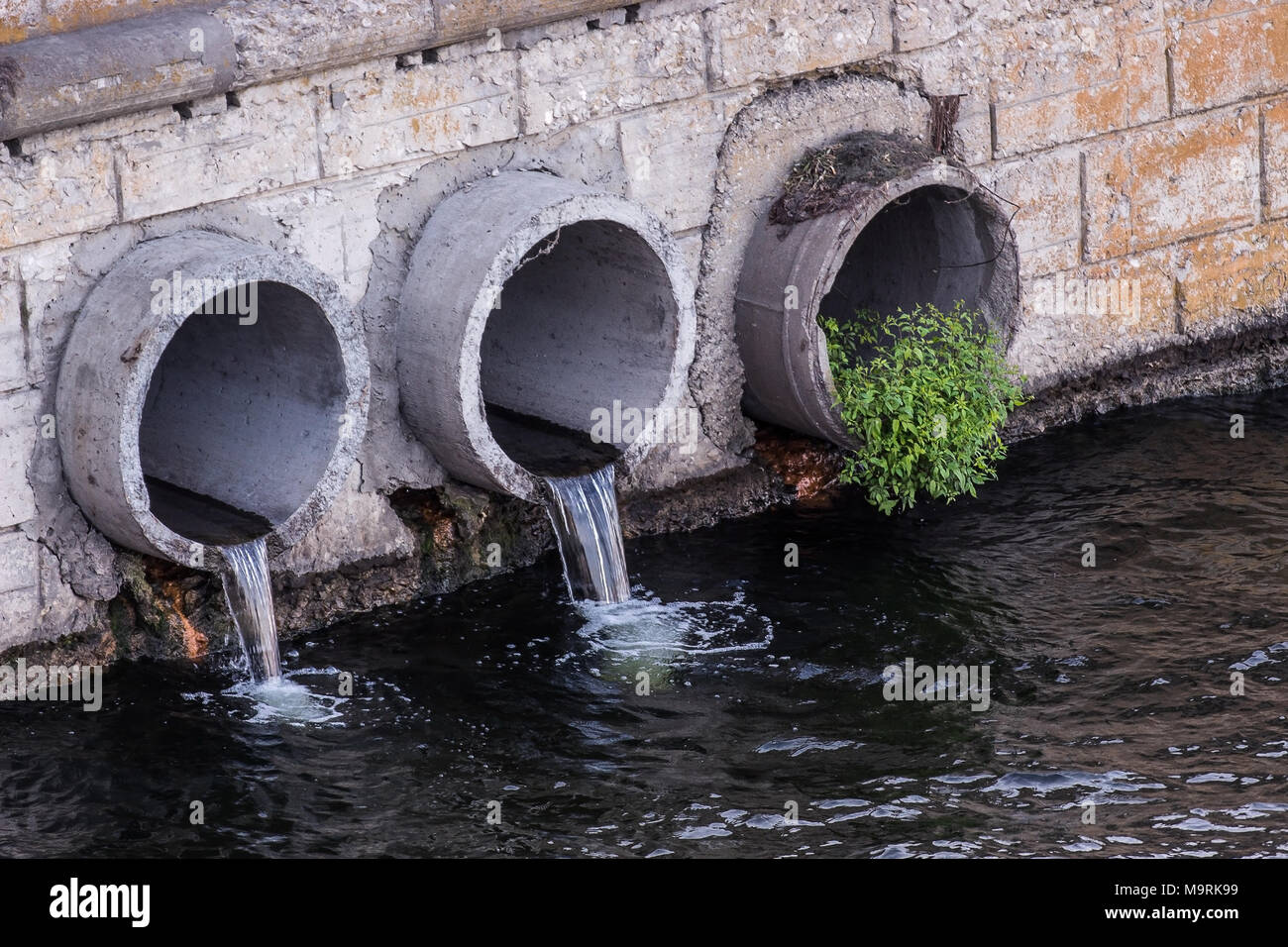 pipes pouring water in the river Stock Photo - Alamy