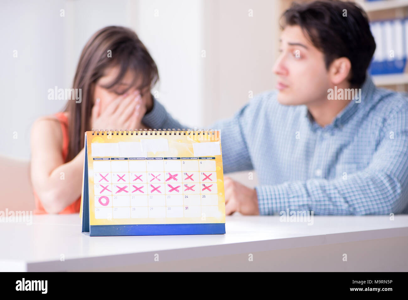 Young family in pregnancy planning concept with ovulation calendar ...