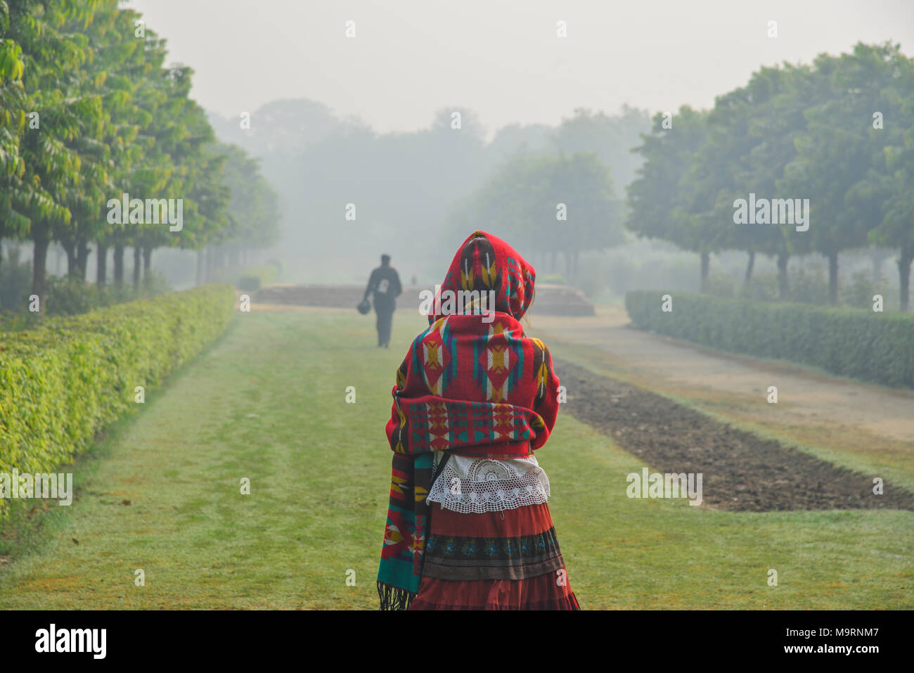 A woman in traditional saree walking at green park in early morning ...