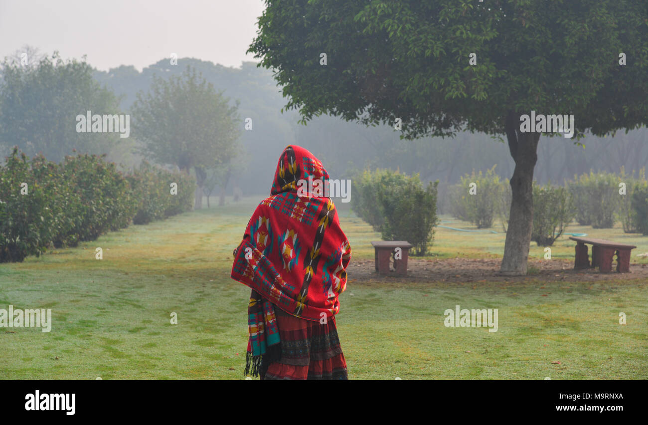 A woman in traditional saree walking at green park in early morning ...