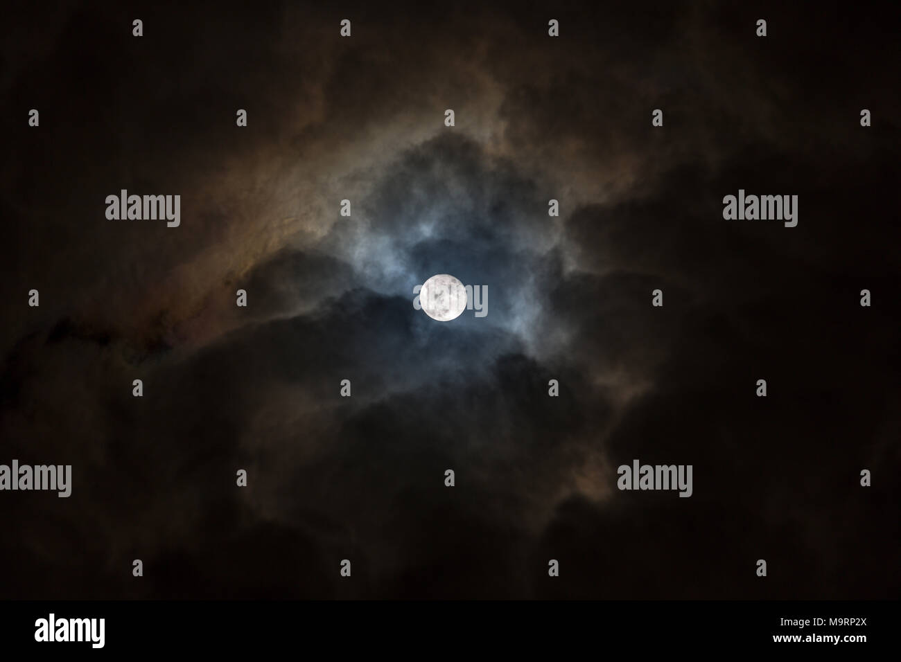 Full moon in a cloudy sky Stock Photo - Alamy