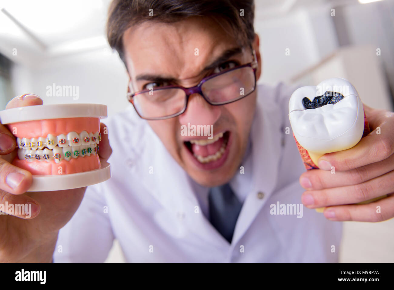 Funny dentist with teeth model in hospital Stock Photo - Alamy