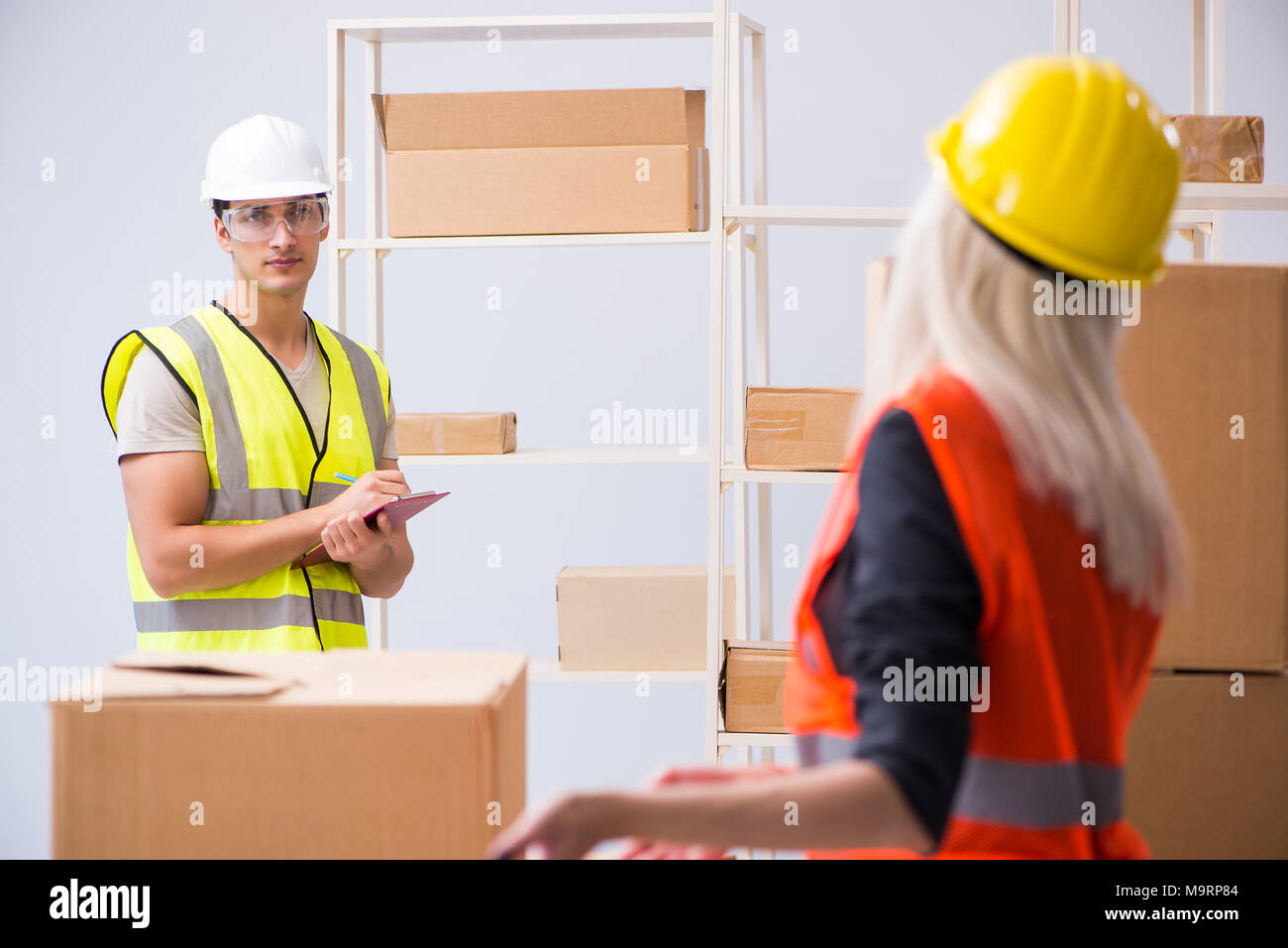 Delivery contractor delivering boxes to office Stock Photo - Alamy